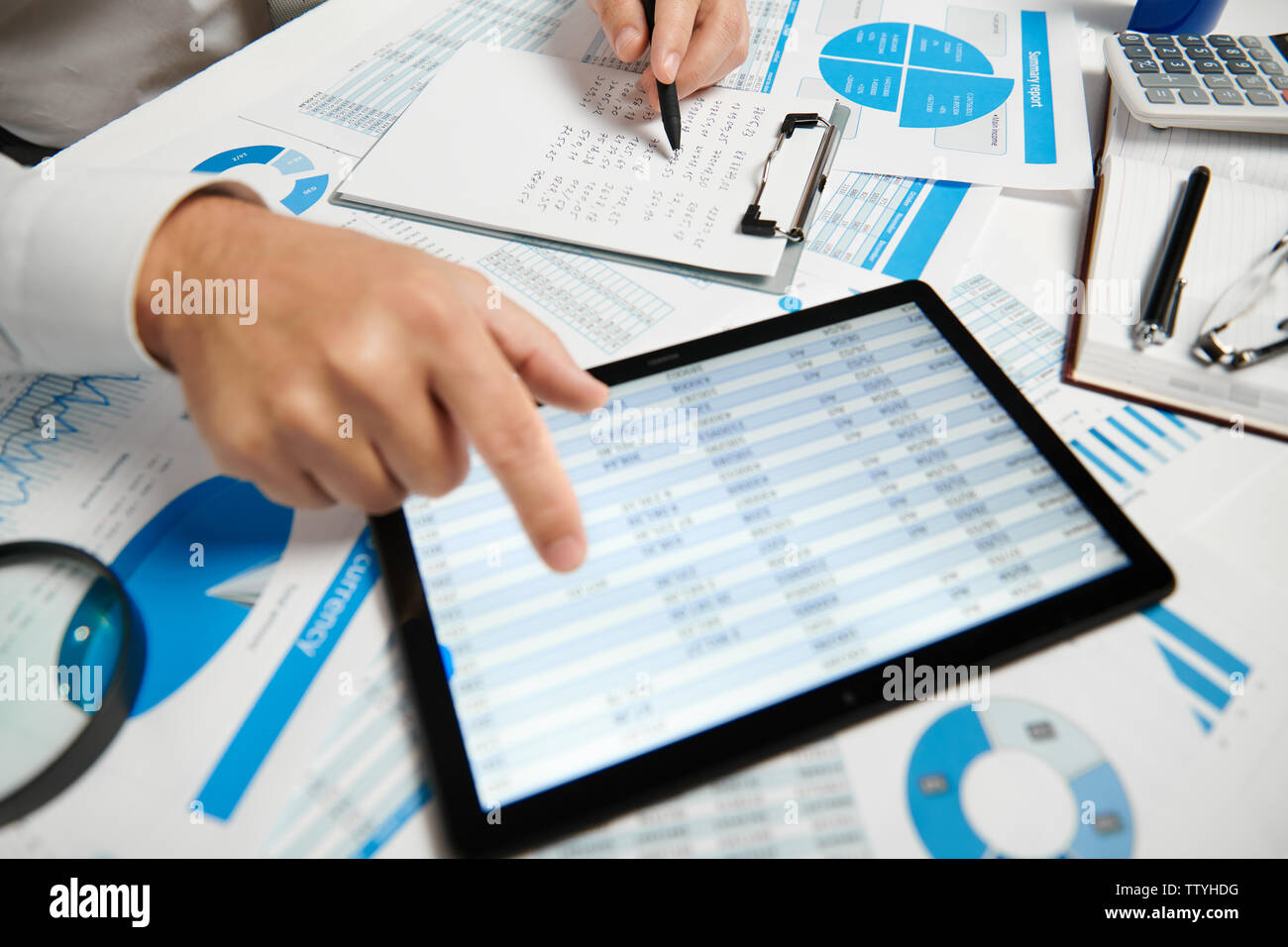 Businessman working and calculating, reads and writes reports. Using ...