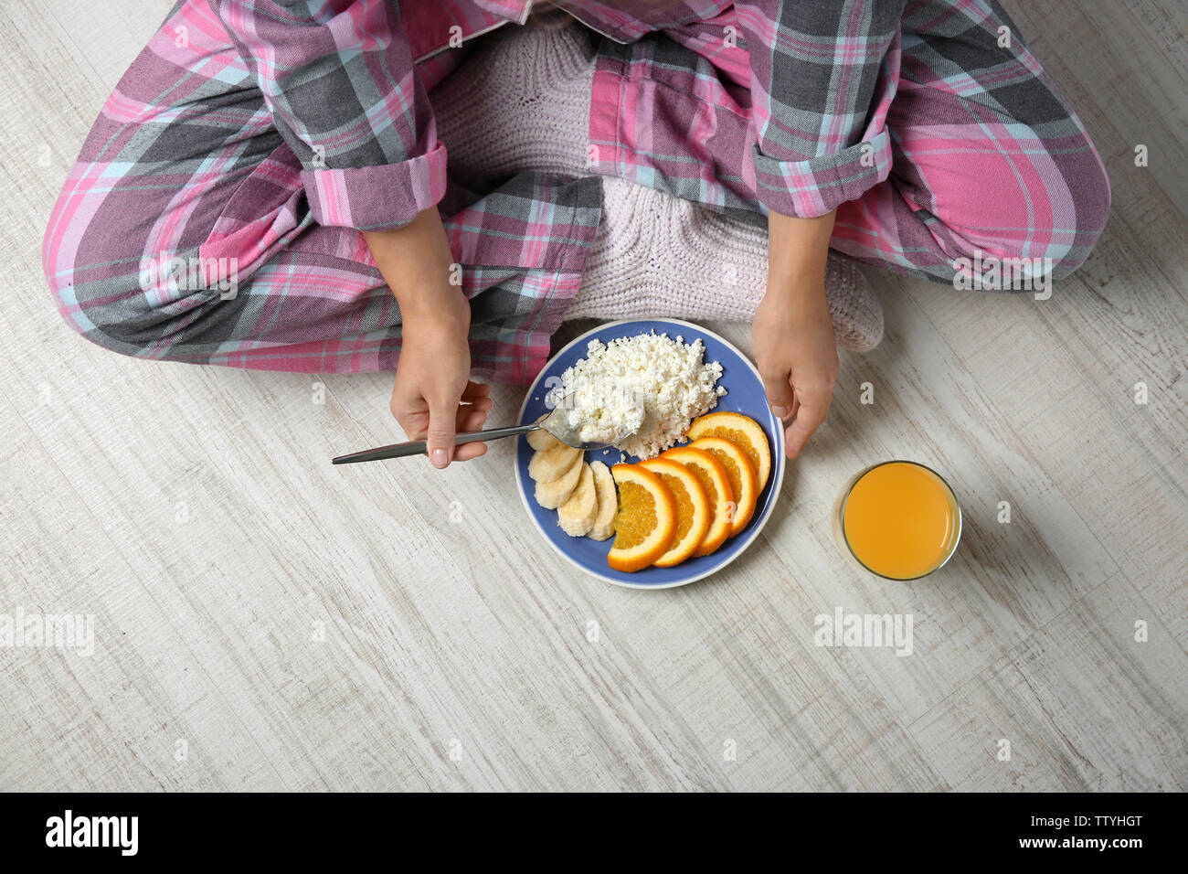 Woman sitting on the floor with healthy breakfast Stock Photo - Alamy