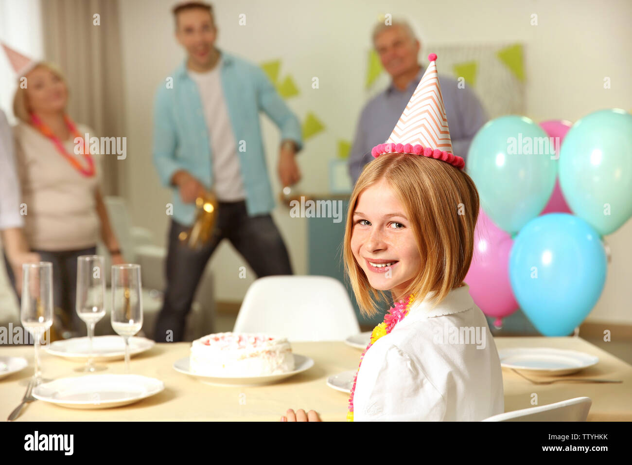 Birthday party. Cute little girl sitting at table Stock Photo - Alamy