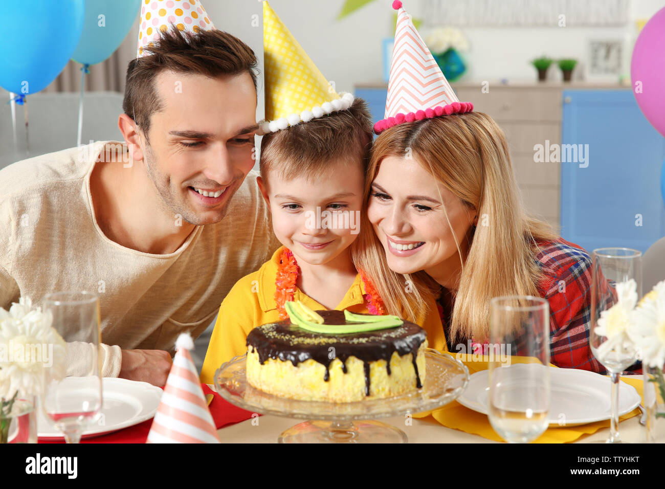 Birthday party. Family sitting at served table Stock Photo - Alamy