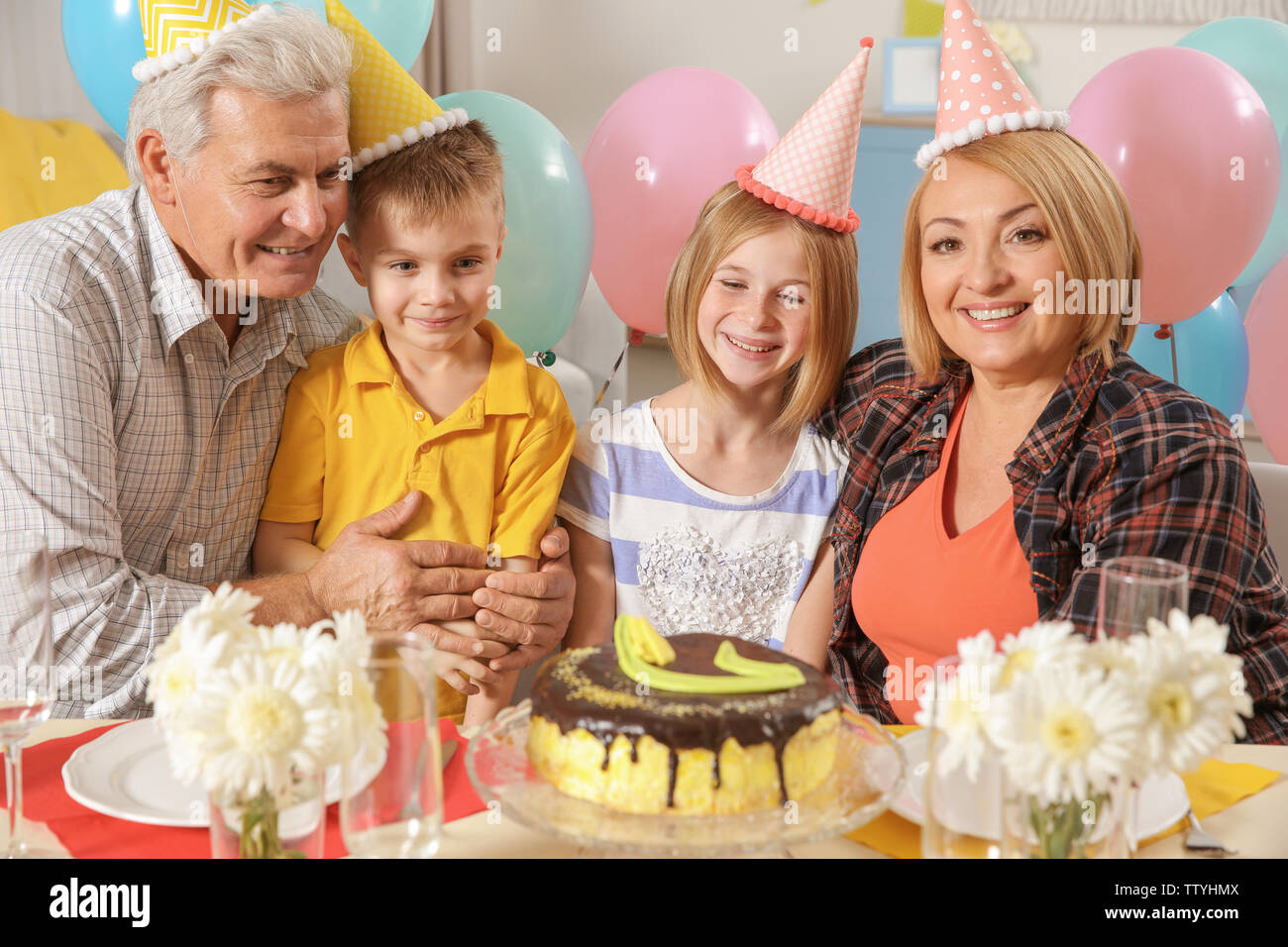 Birthday party. Family sitting at served table Stock Photo - Alamy