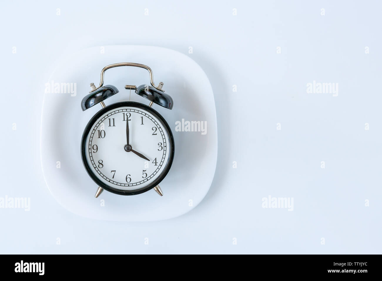 Alarm clock on the white plate. Time to eat, Breakfast, Lunch time and ...