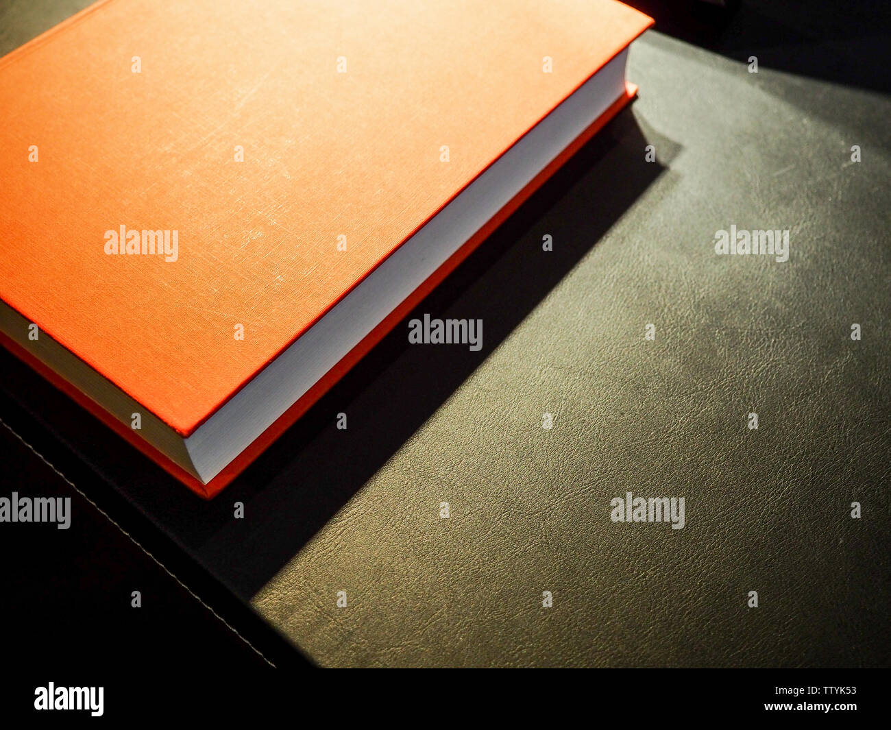 Red hardback book on black table, Office dark table. Mock up book blank ...