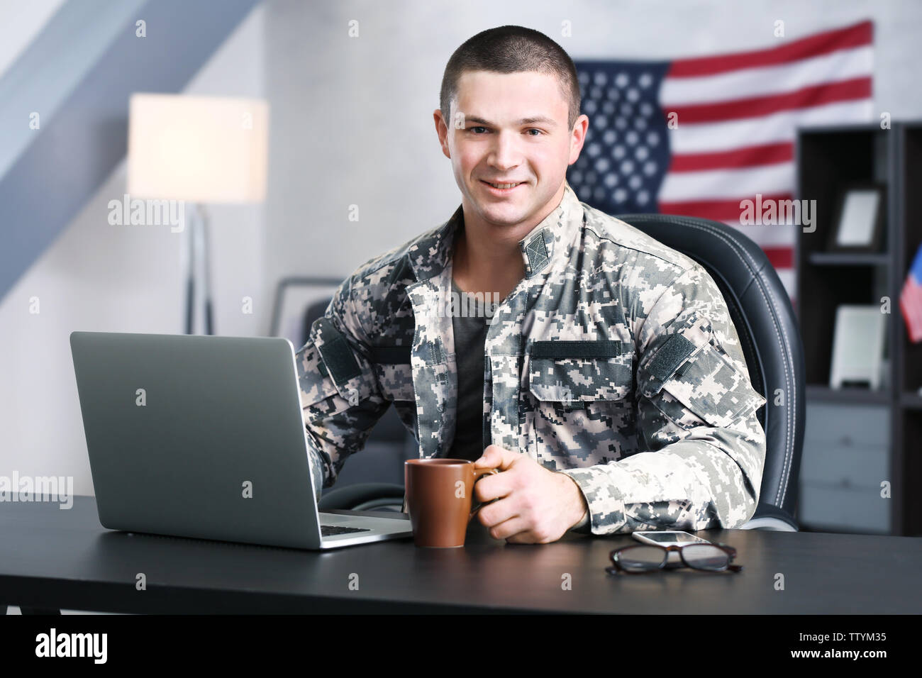 Soldier working with laptop in headquarters building Stock Photo - Alamy