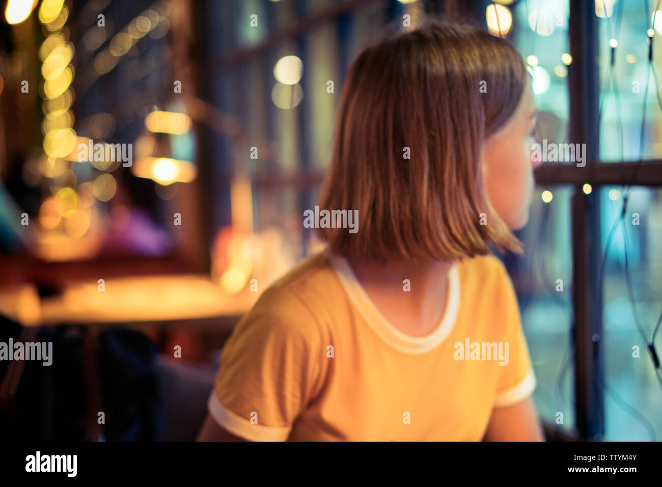 Beautiful young girl in restaurant look out the window Stock Photo - Alamy
