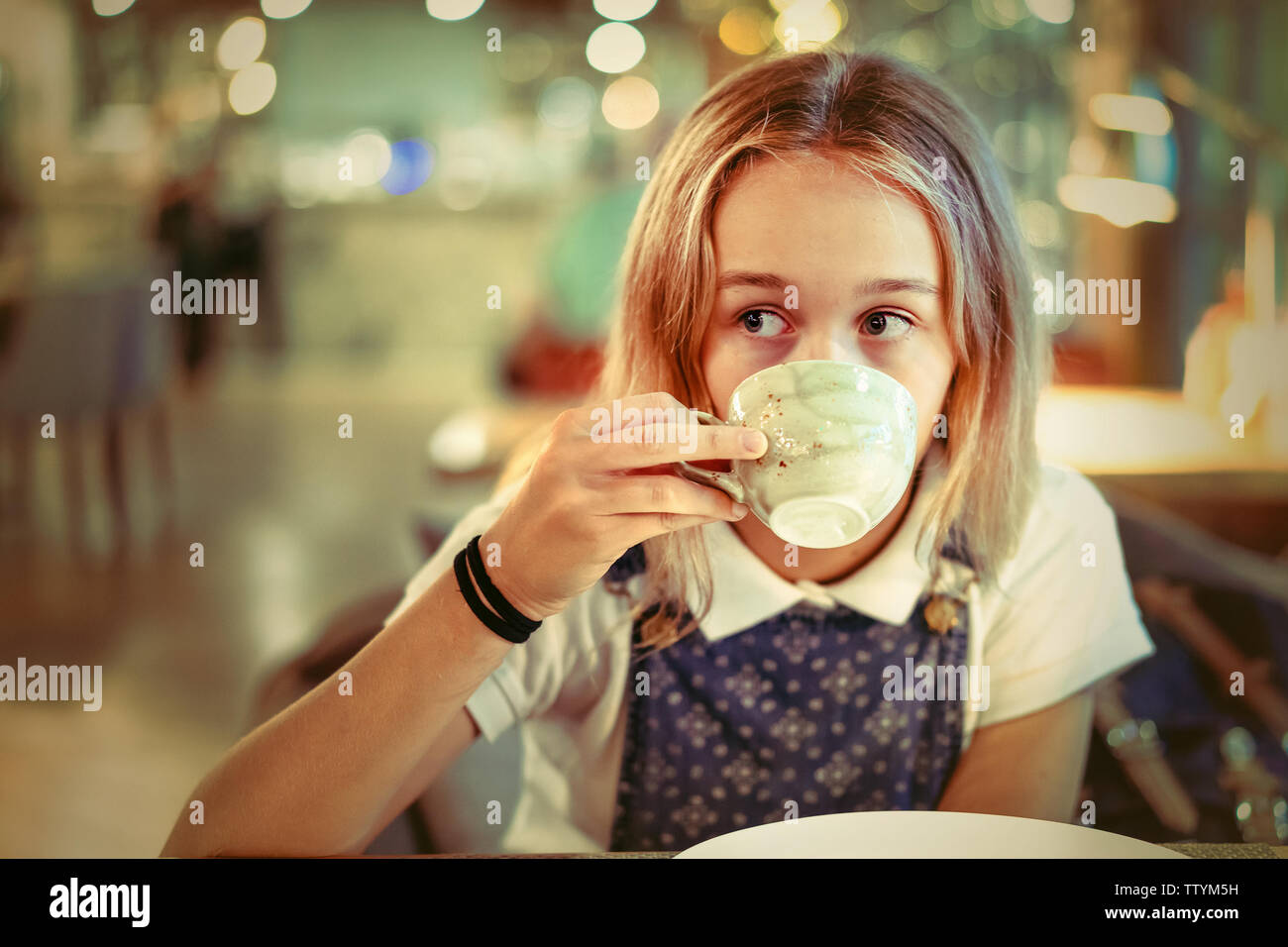 Pretty young girl drinking tea in the restaurant Stock Photo - Alamy