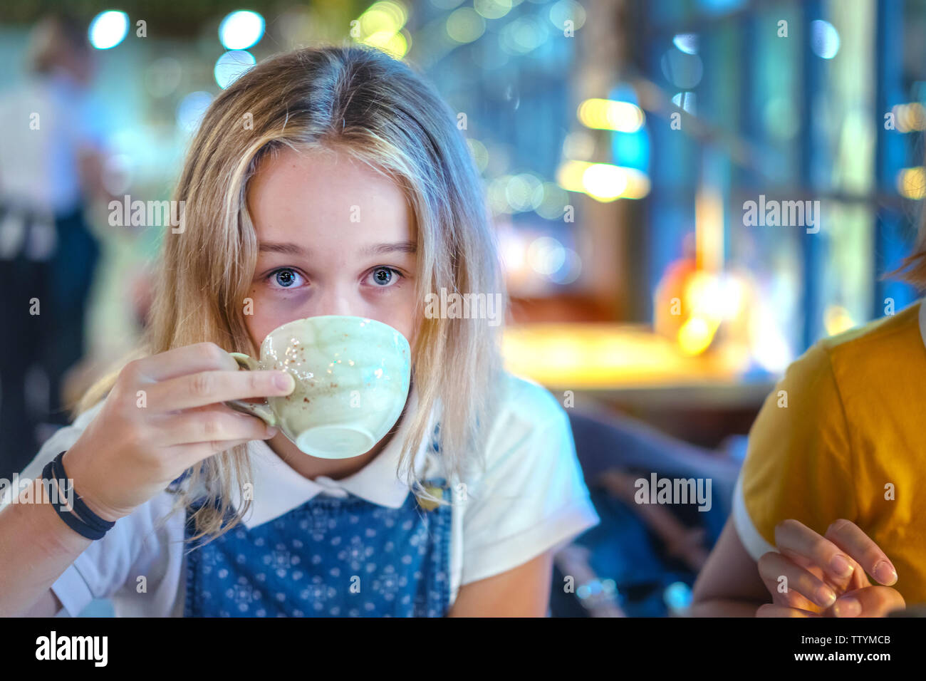 Pretty young girl drinking tea in the restaurant Stock Photo - Alamy