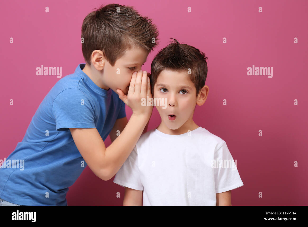Cute little brothers standing on pink background Stock Photo - Alamy