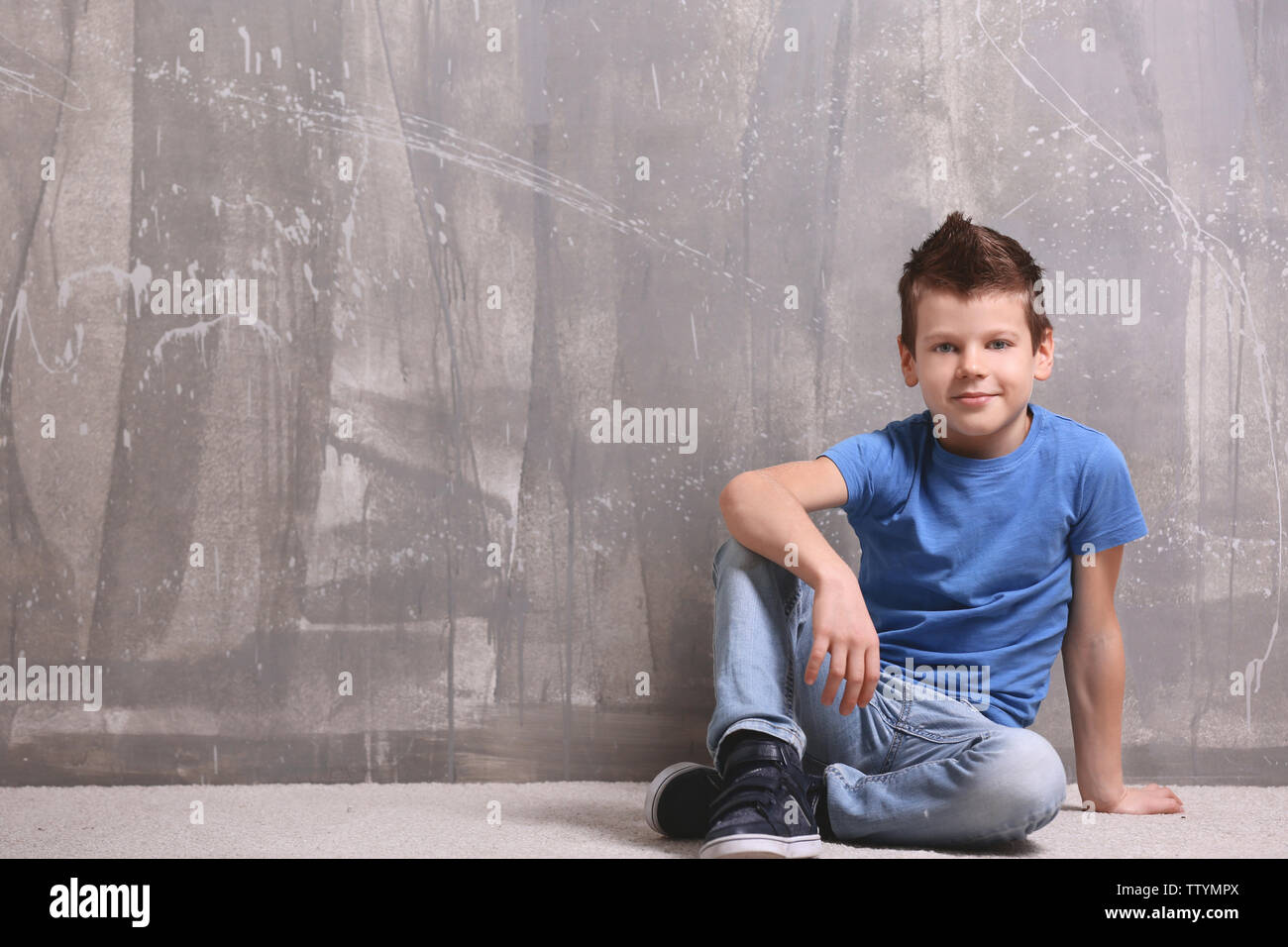 Cute little boy on grey textured background Stock Photo - Alamy