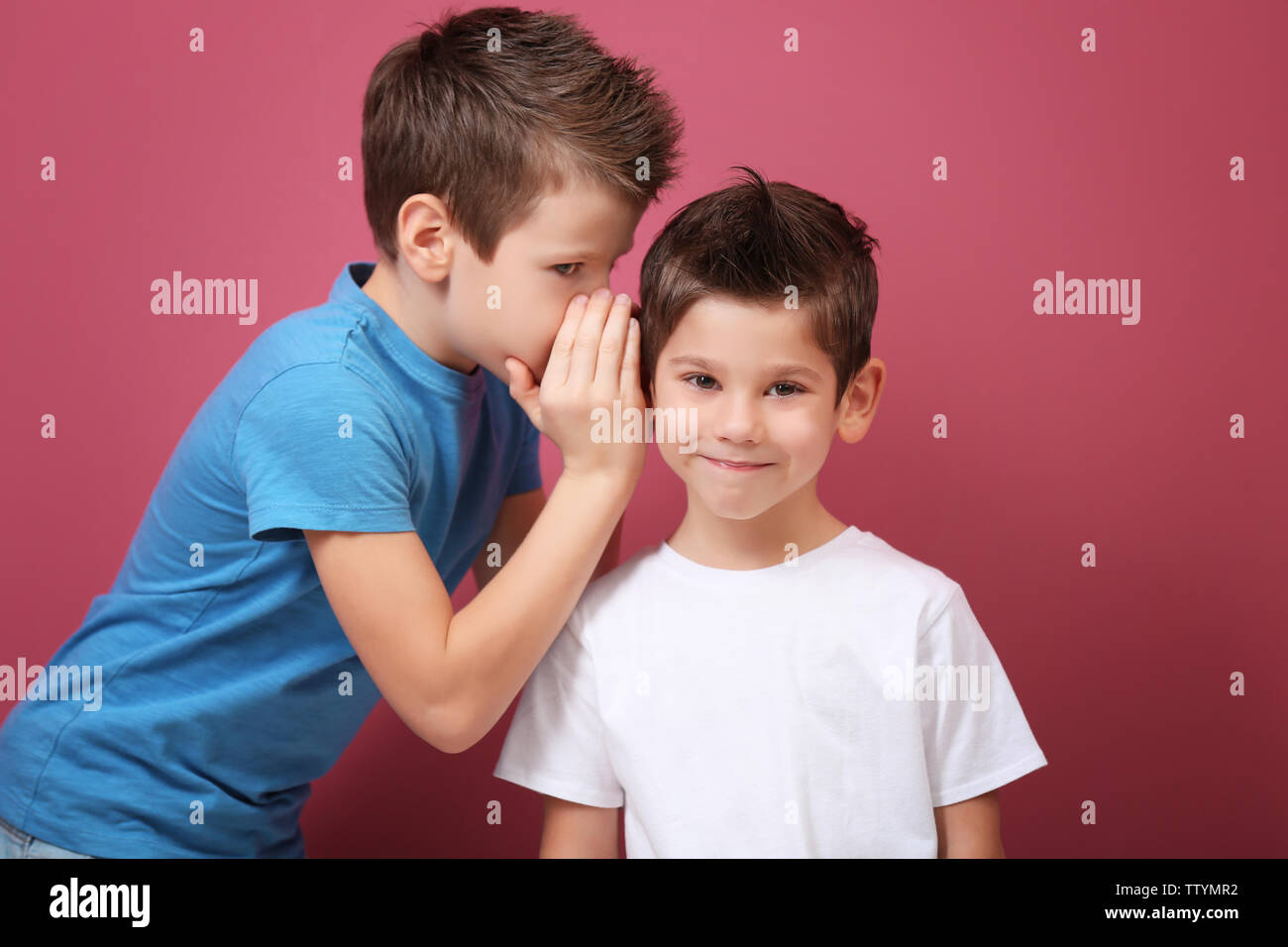 Cute little brothers standing on pink background Stock Photo - Alamy