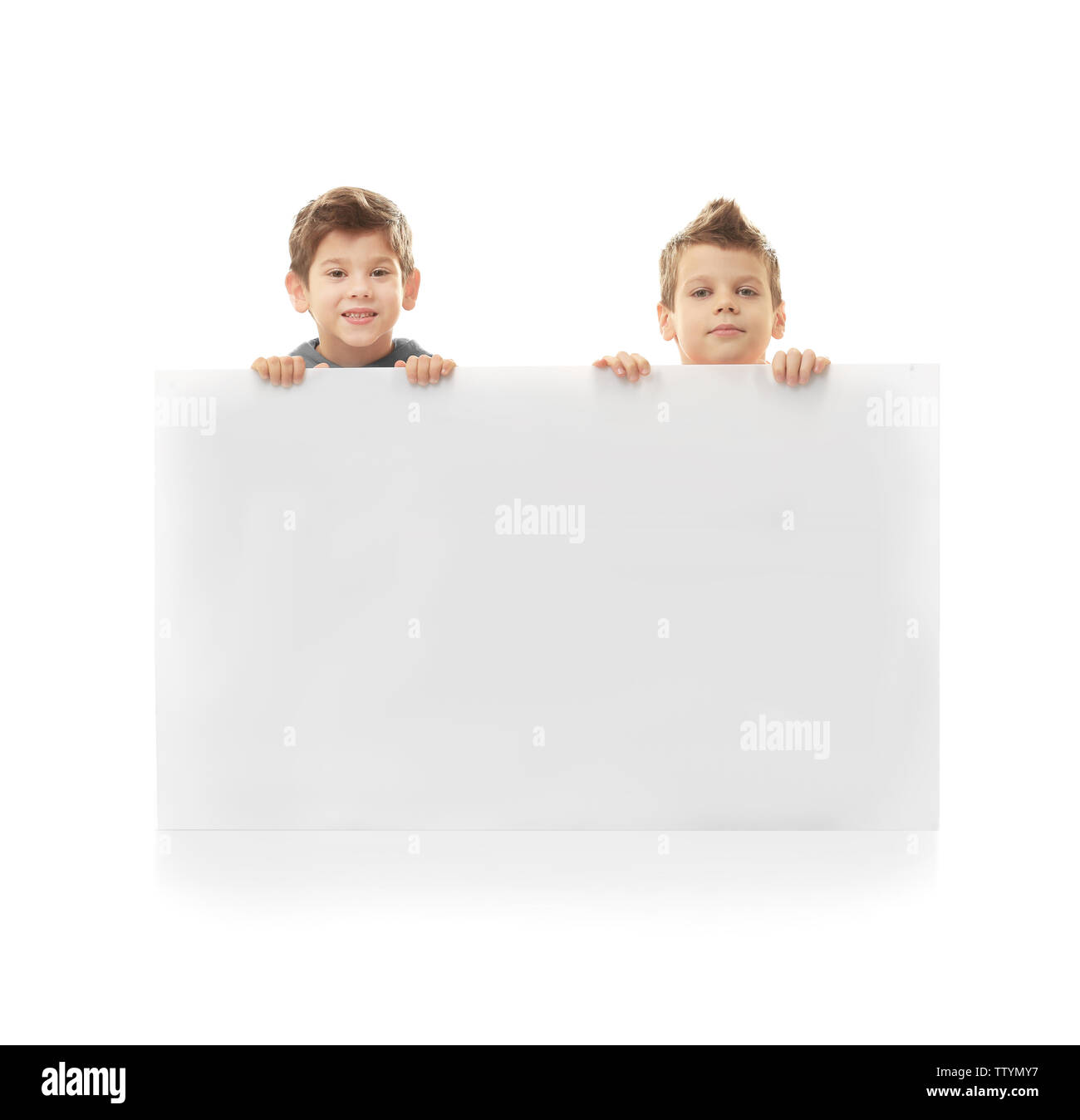 Cute little brothers standing behind board on white background Stock ...