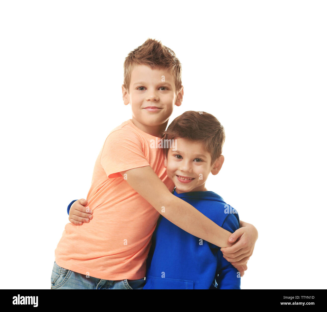 Cute little brothers standing on white background Stock Photo - Alamy