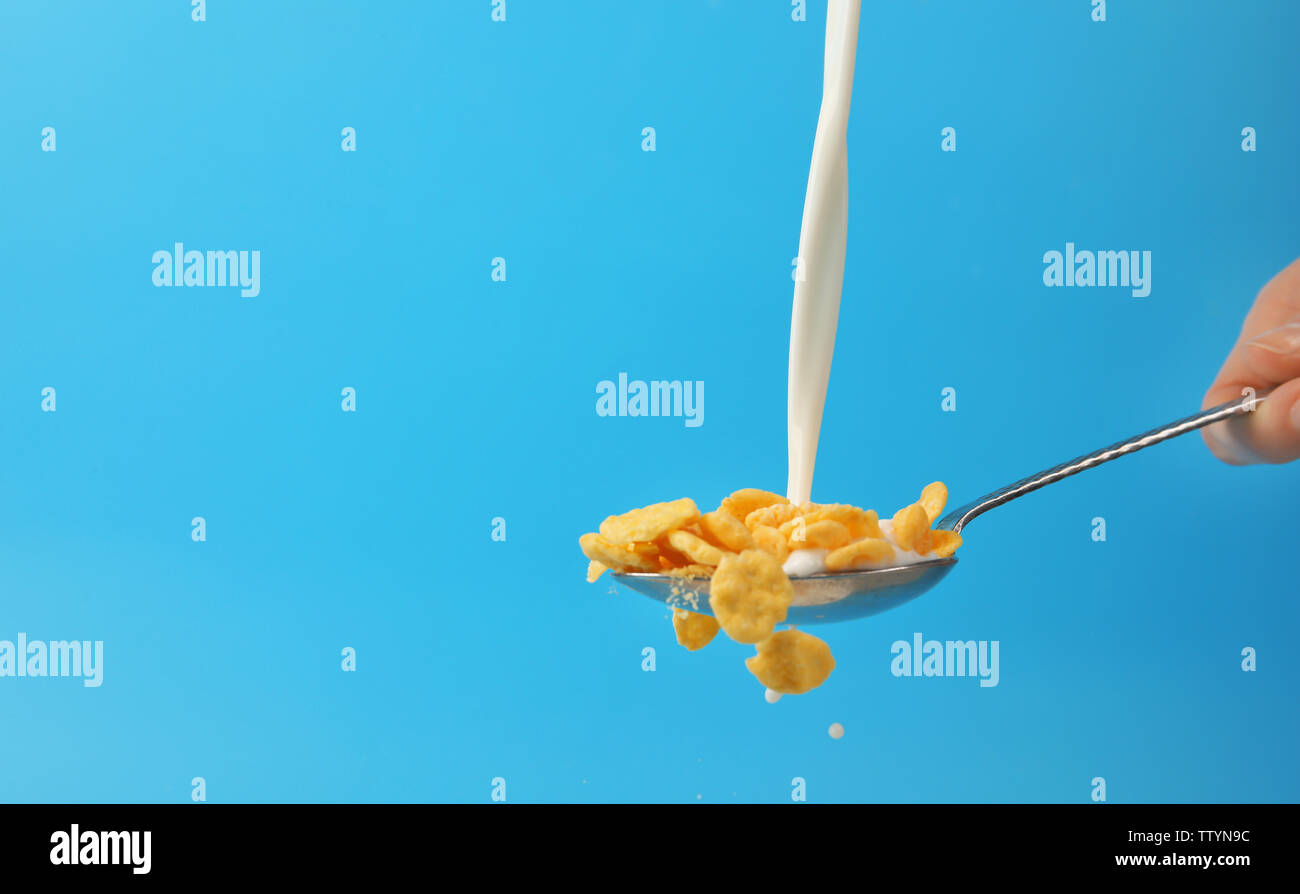Stream of milk pouring into spoon with corn flakes Stock Photo - Alamy