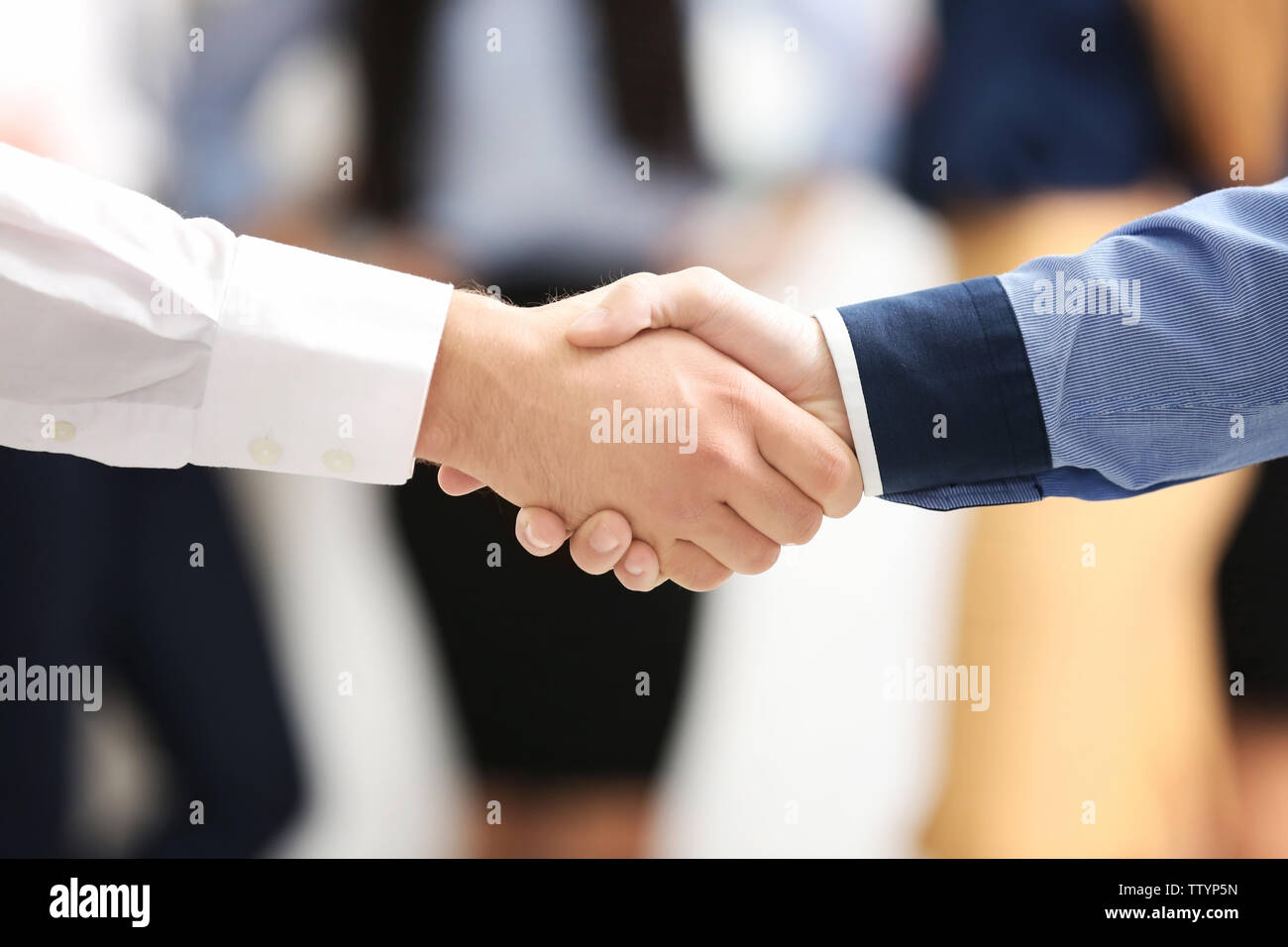 Handshaking of business partners on blurred people background Stock ...
