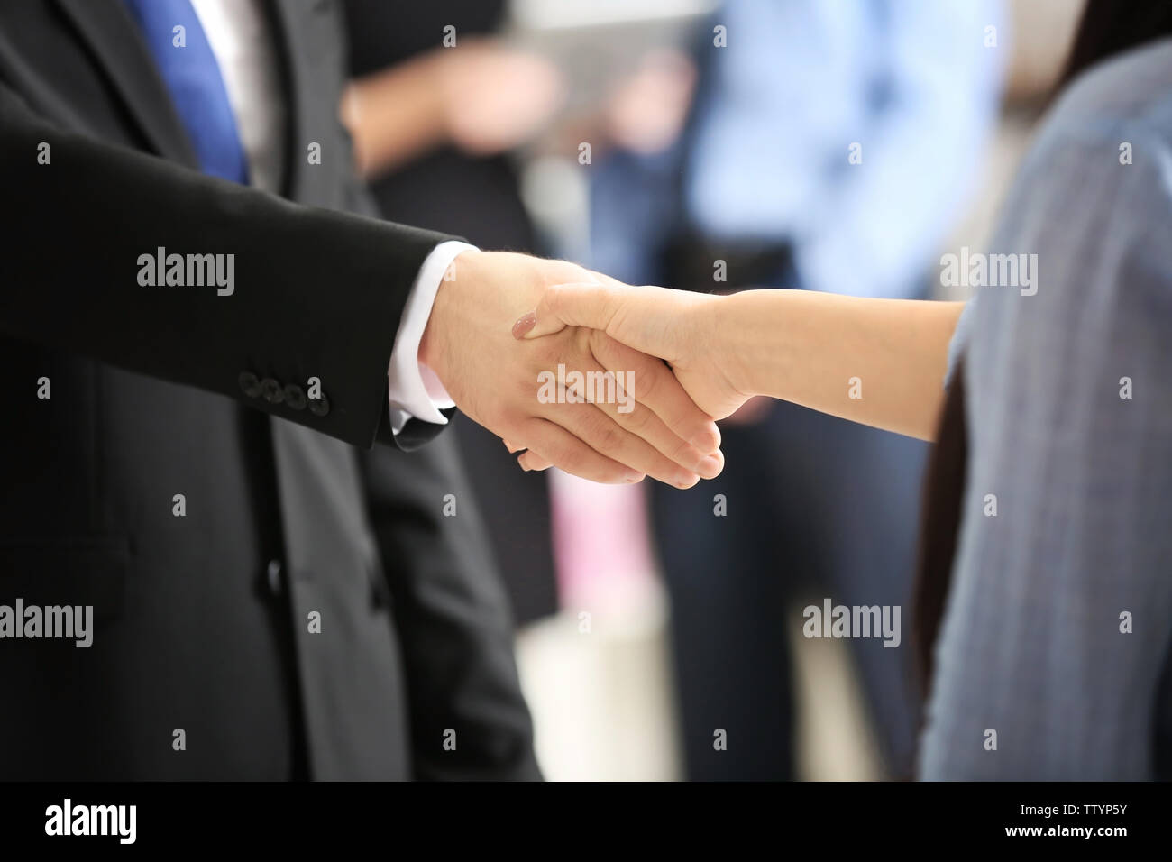 Handshaking of business partners on blurred people background Stock ...