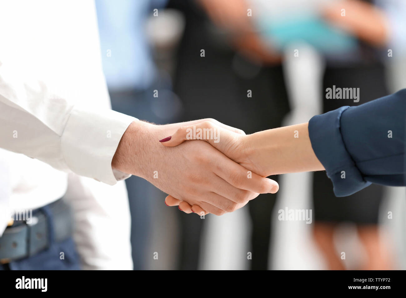 Handshaking of business partners on blurred people background Stock ...