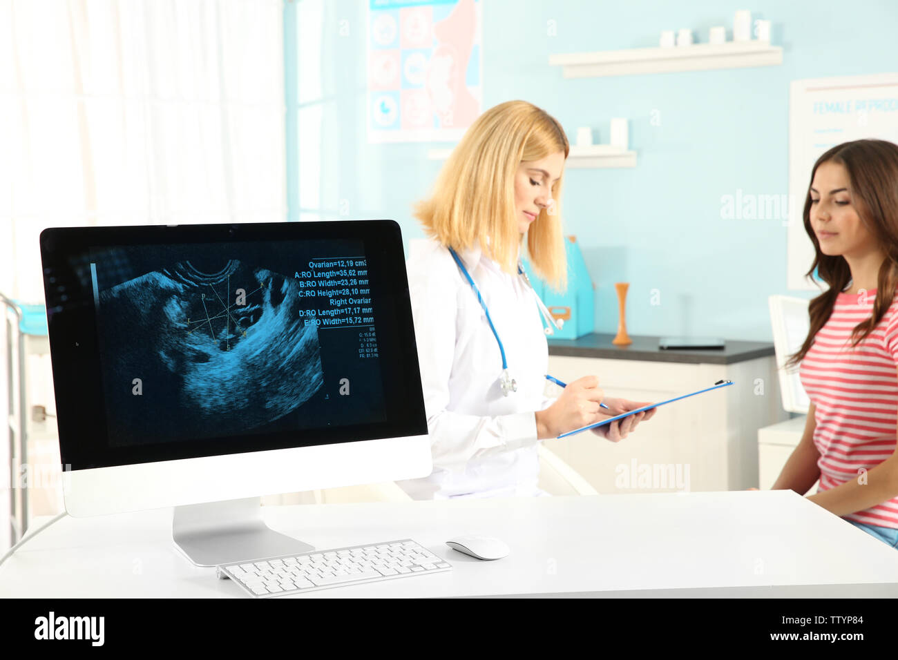 Computer with ultrasound scan with doctor and patient on background ...