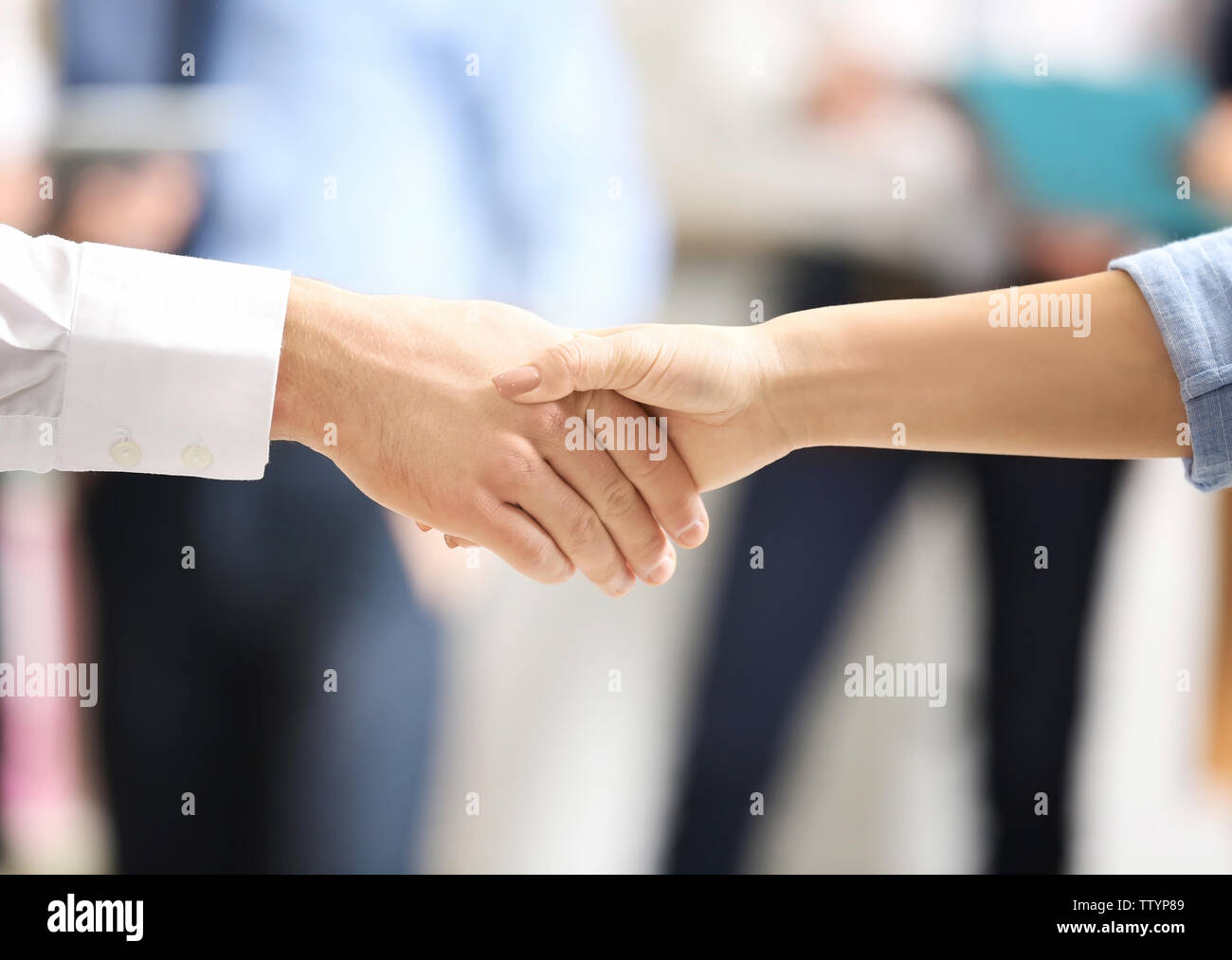 Handshaking of business partners on blurred people background Stock ...