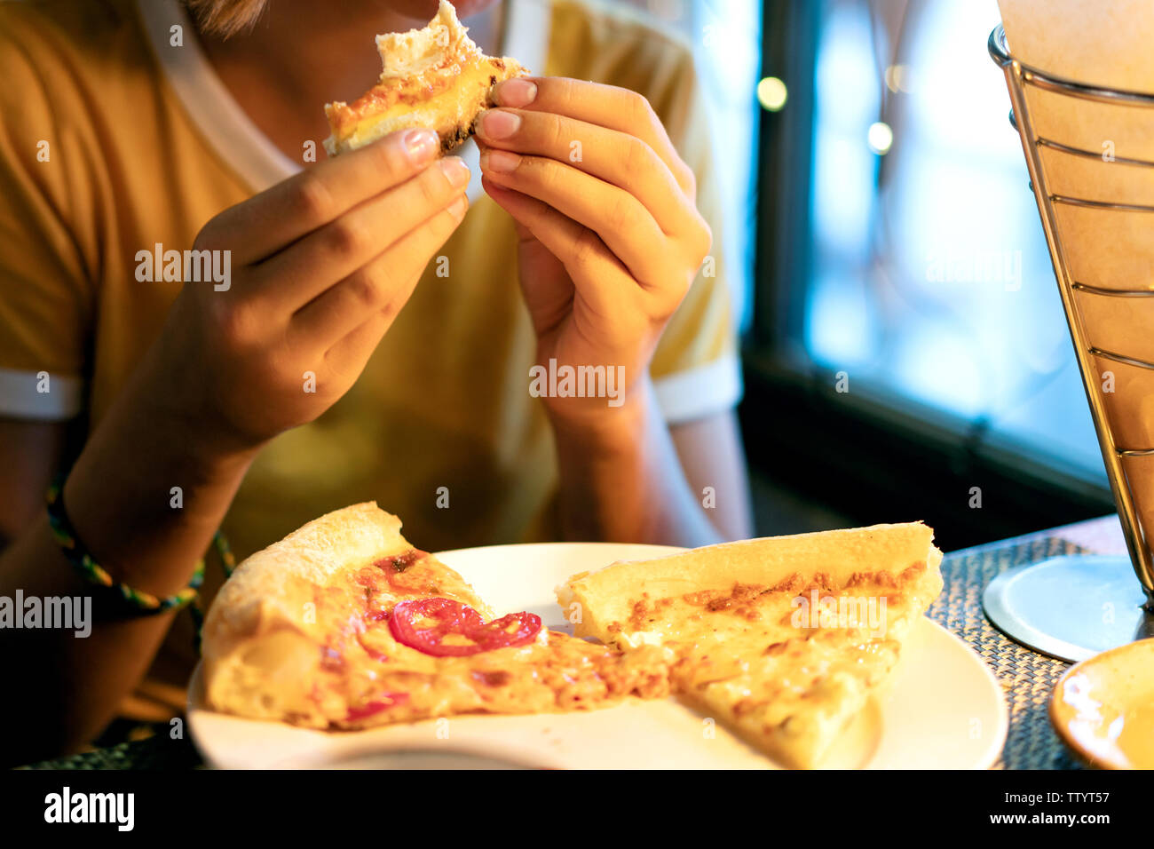 Beautiful young girl eating a slice of pizza in a restaurant Stock ...