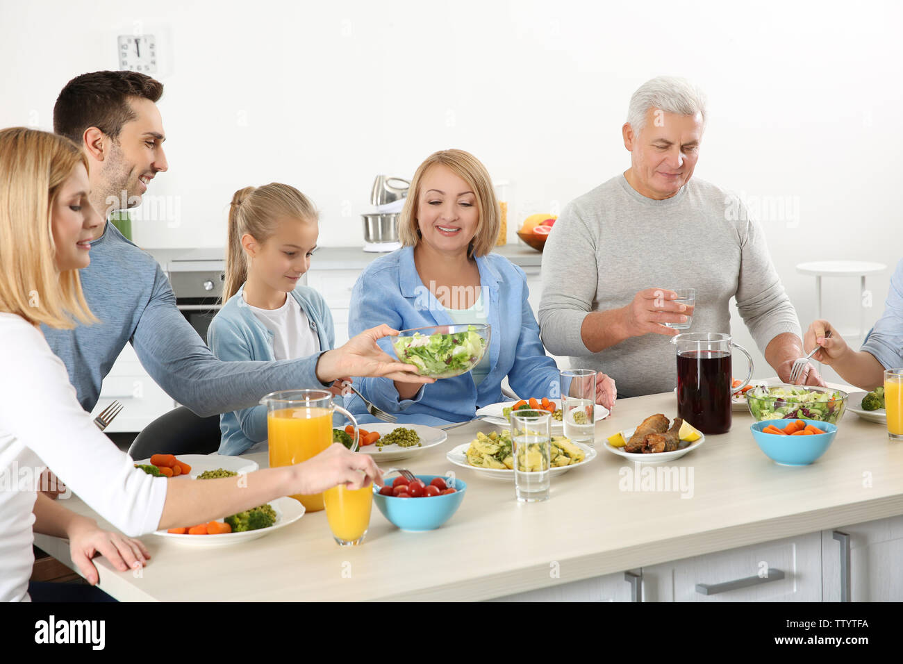 Happy family having lunch in kitchen Stock Photo - Alamy