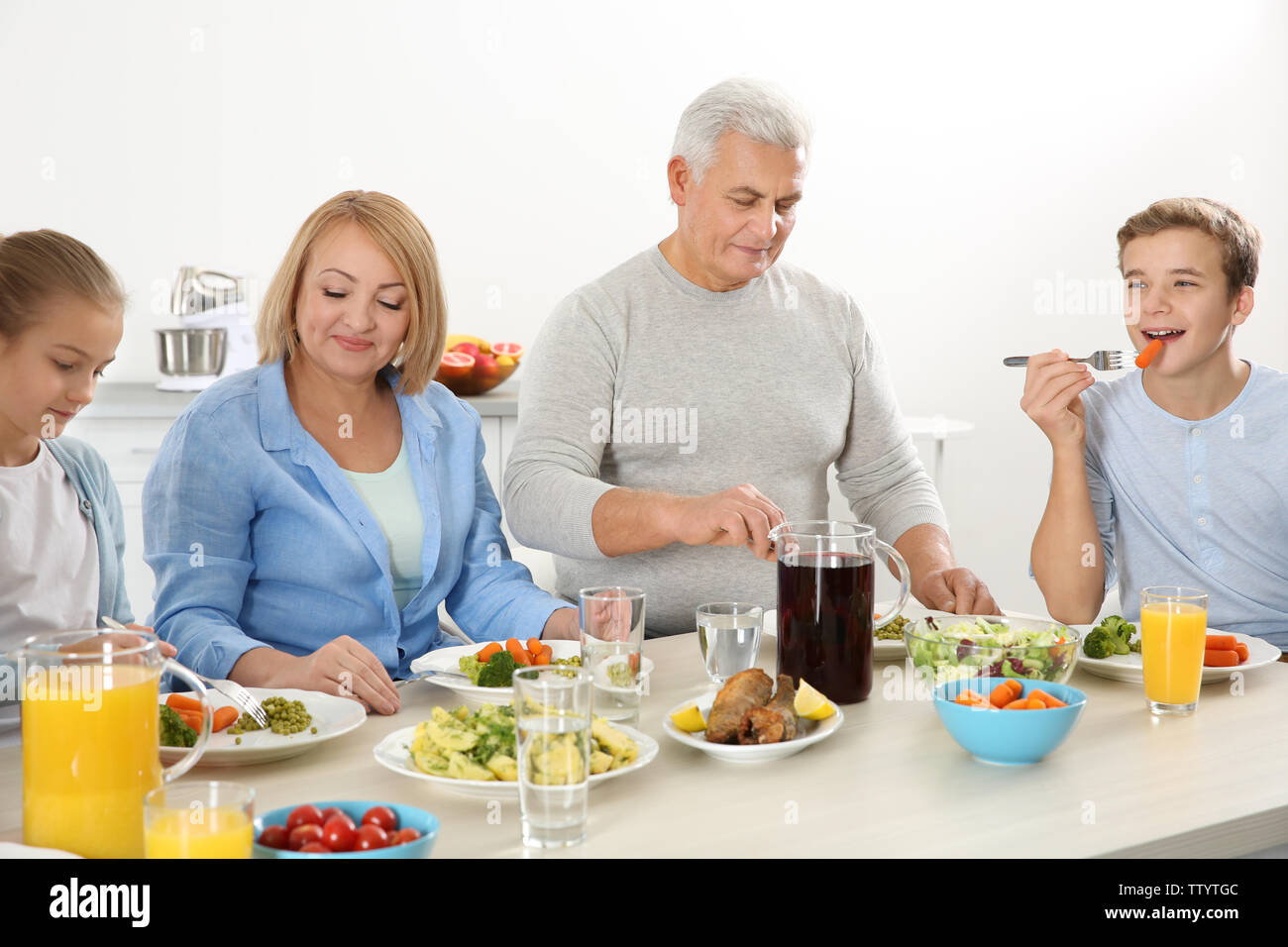 Happy family having lunch in kitchen Stock Photo - Alamy