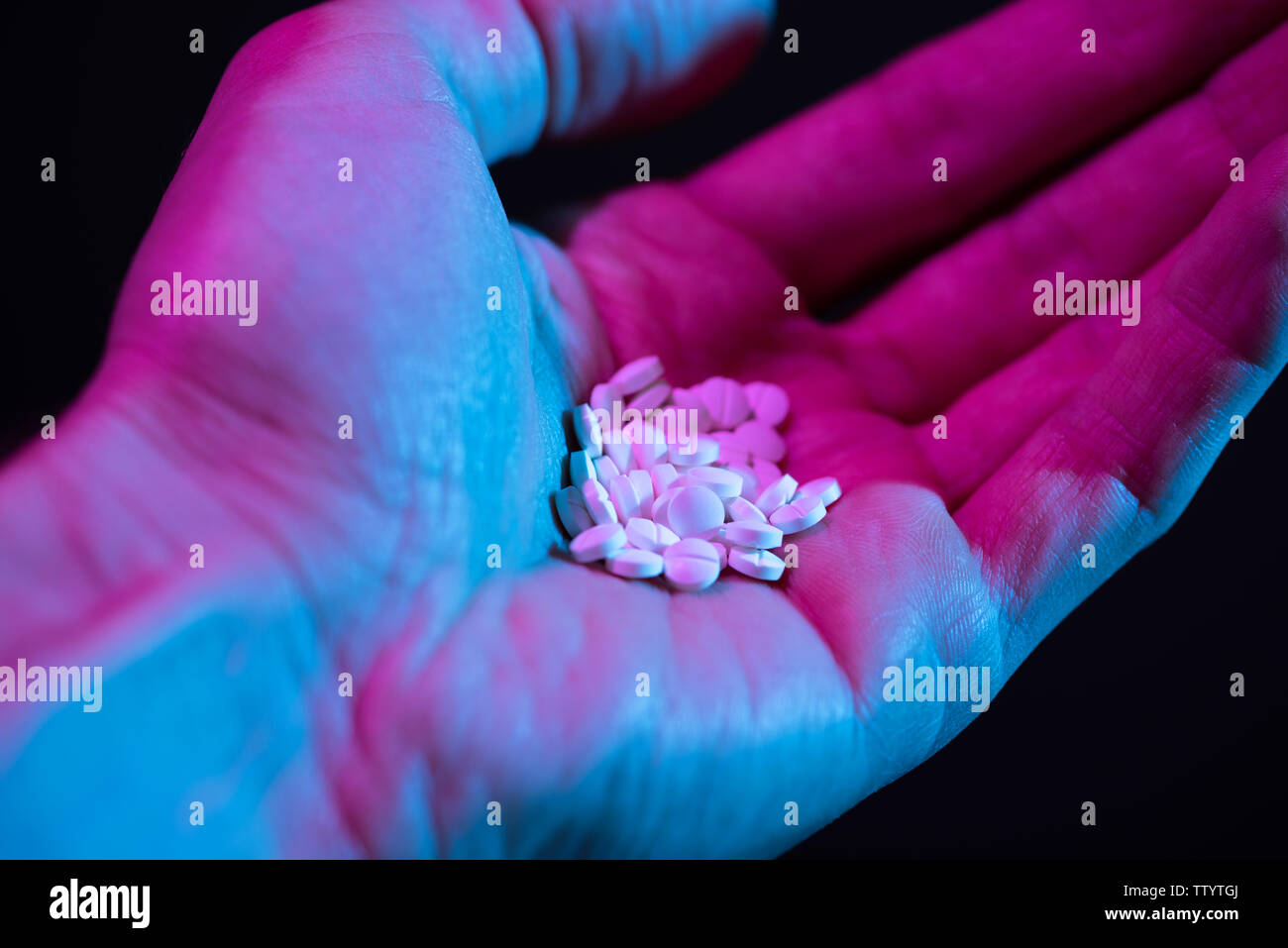 Pills pile in hand. Drug tablets in palm close-up on dark background ...