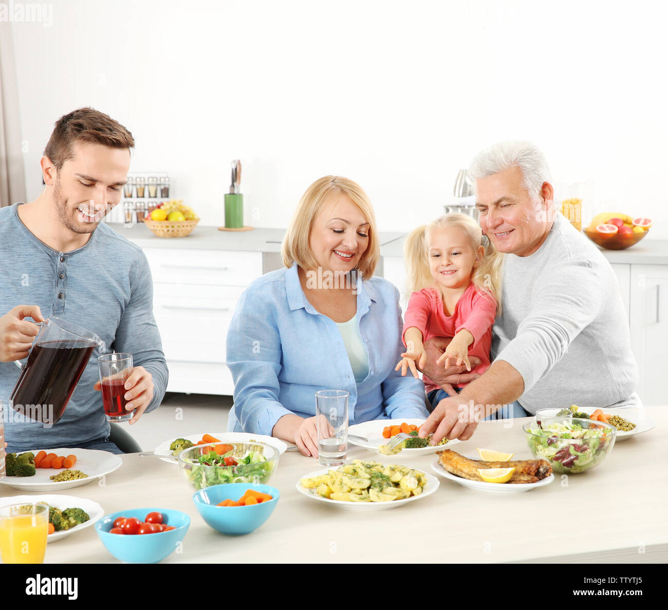 Happy family having lunch in kitchen Stock Photo - Alamy