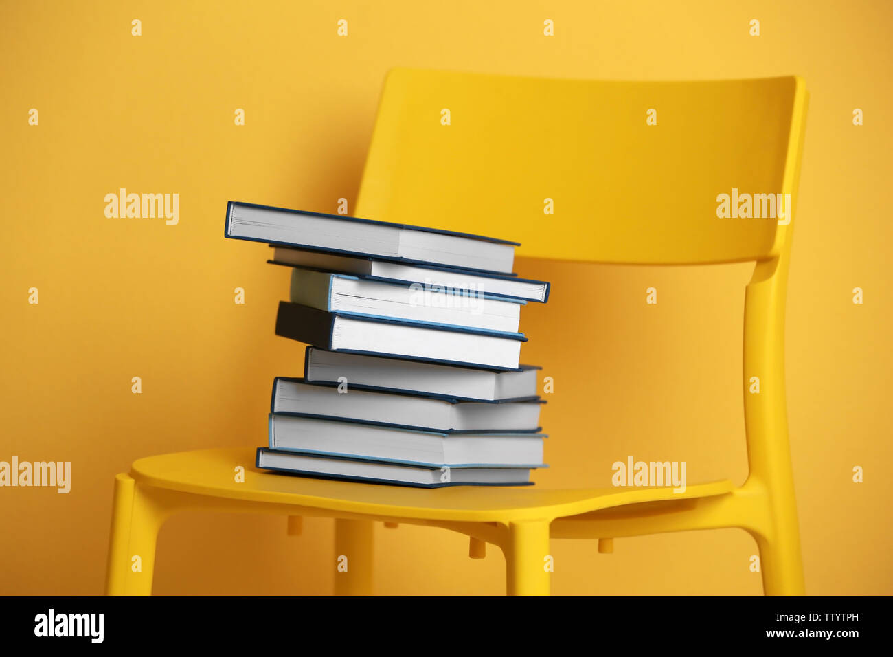 Books on yellow chair hi-res stock photography and images - Alamy