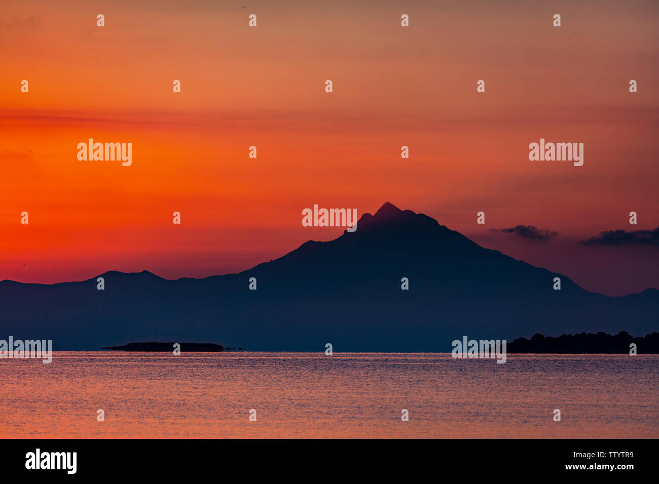 Silhouette of mountain peak above the sea before sunrise Stock Photo ...