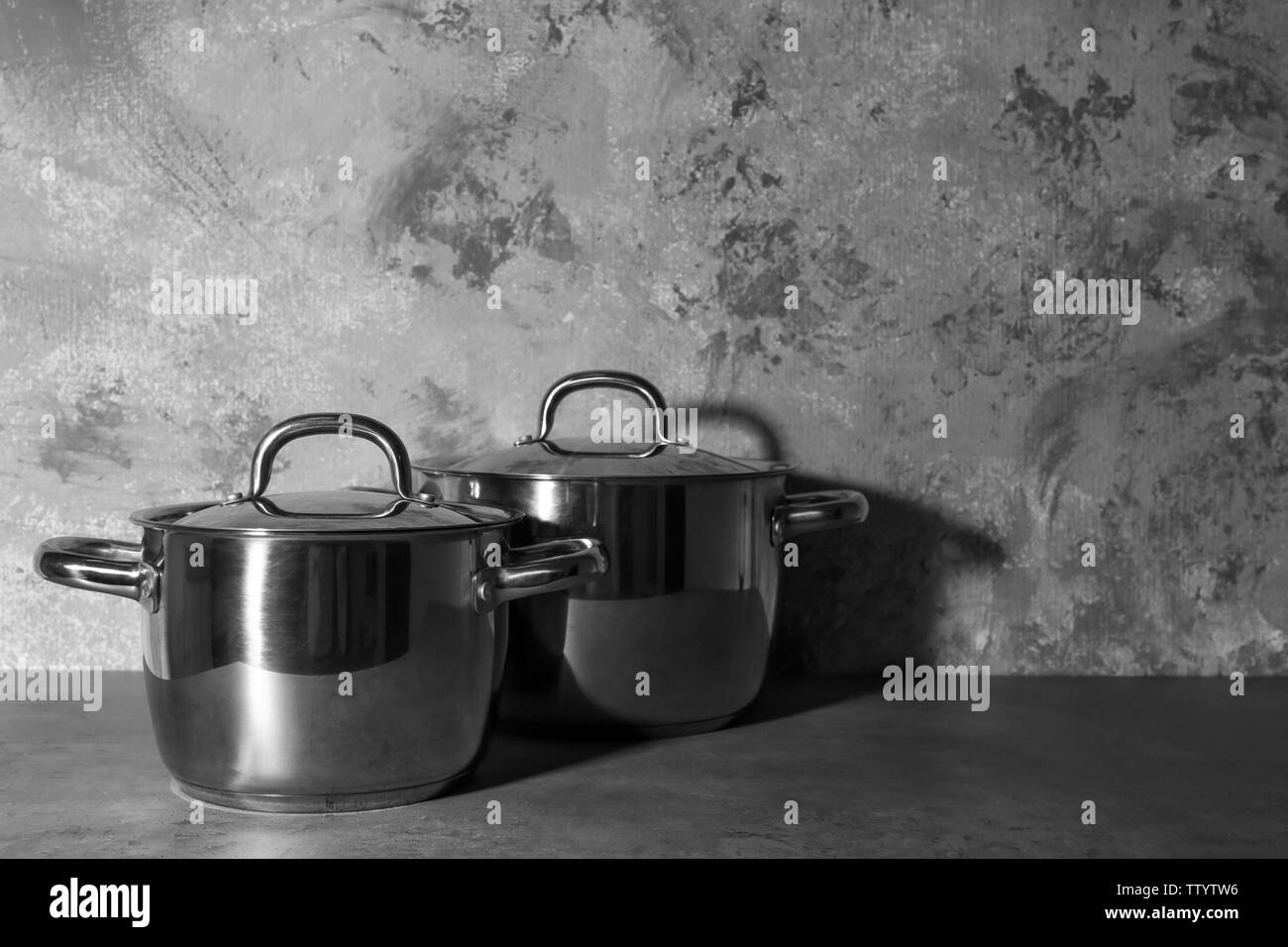 Metal pans with lids on textured wall background Stock Photo - Alamy