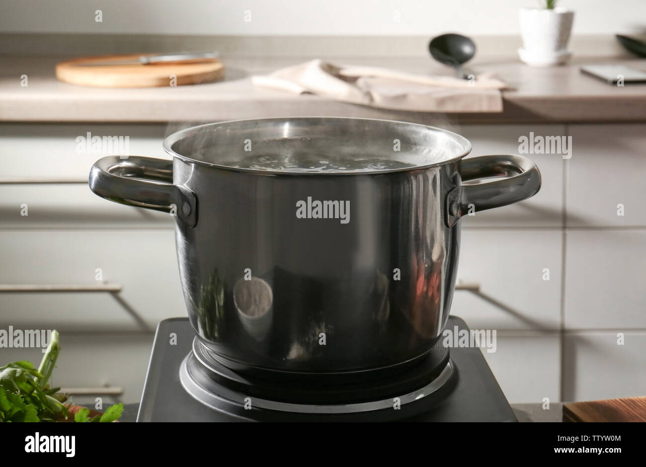 Pan with boiled water on hotplate in kitchen Stock Photo - Alamy