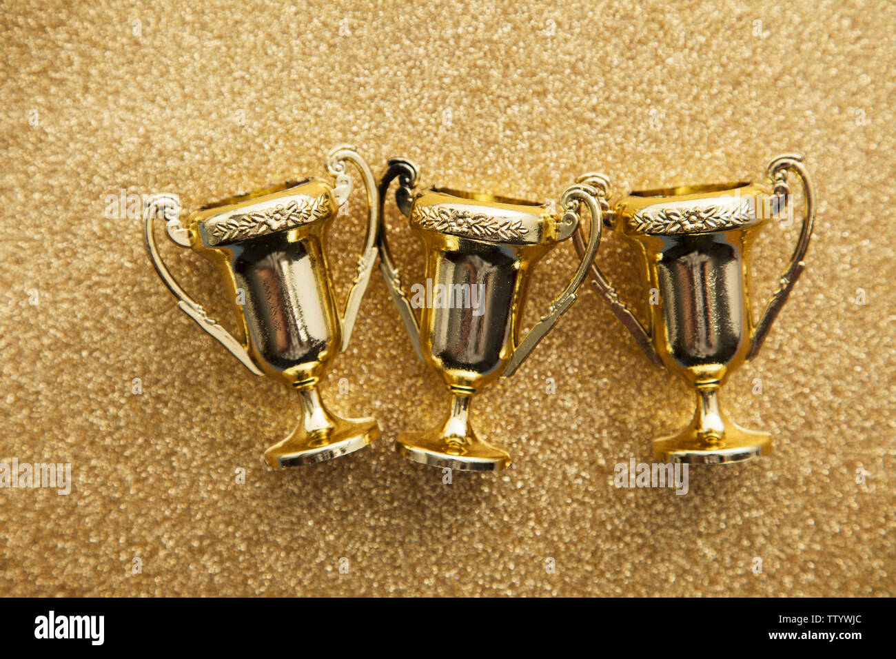 Gold winners achievement trophy on a gold glitter background Stock ...