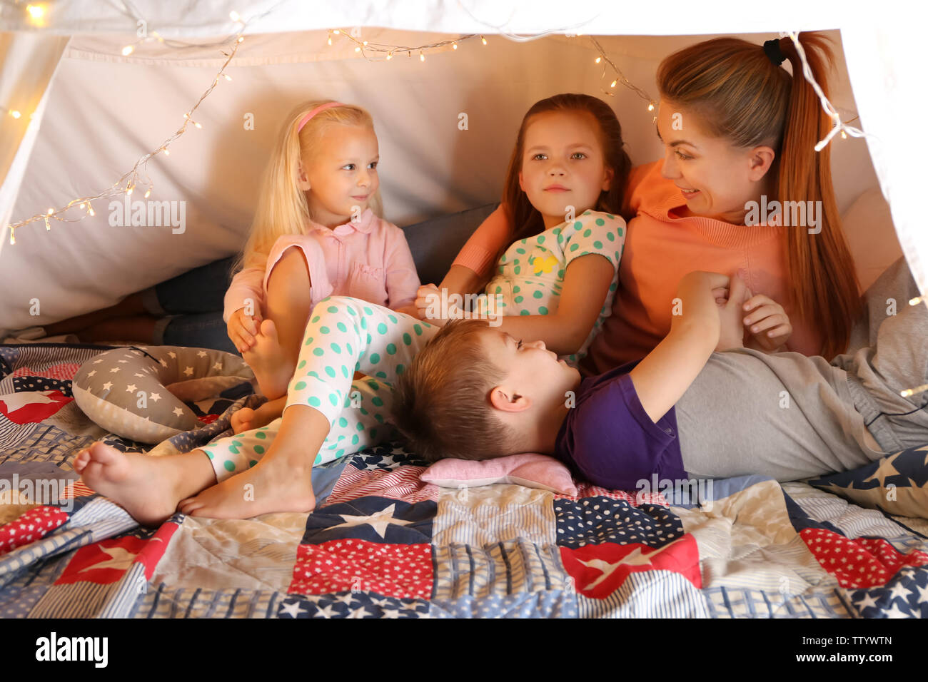 Young woman and cute children playing in hovel at home Stock Photo - Alamy