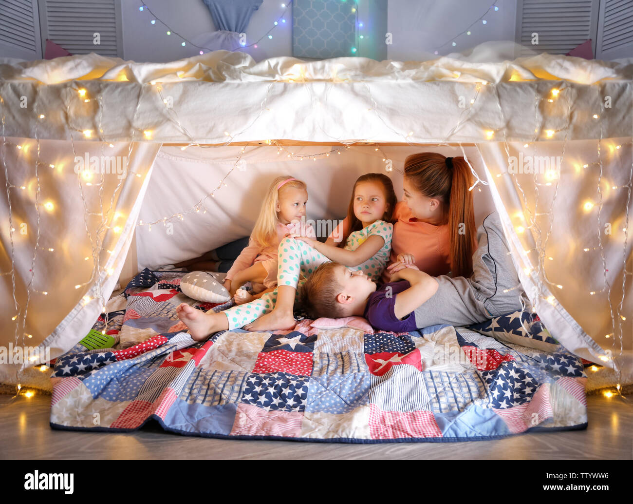 Young woman and cute children playing in hovel at home Stock Photo - Alamy