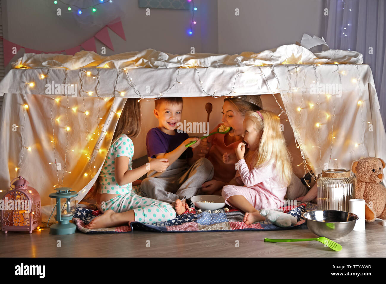 Young woman and cute children playing in hovel at home Stock Photo - Alamy