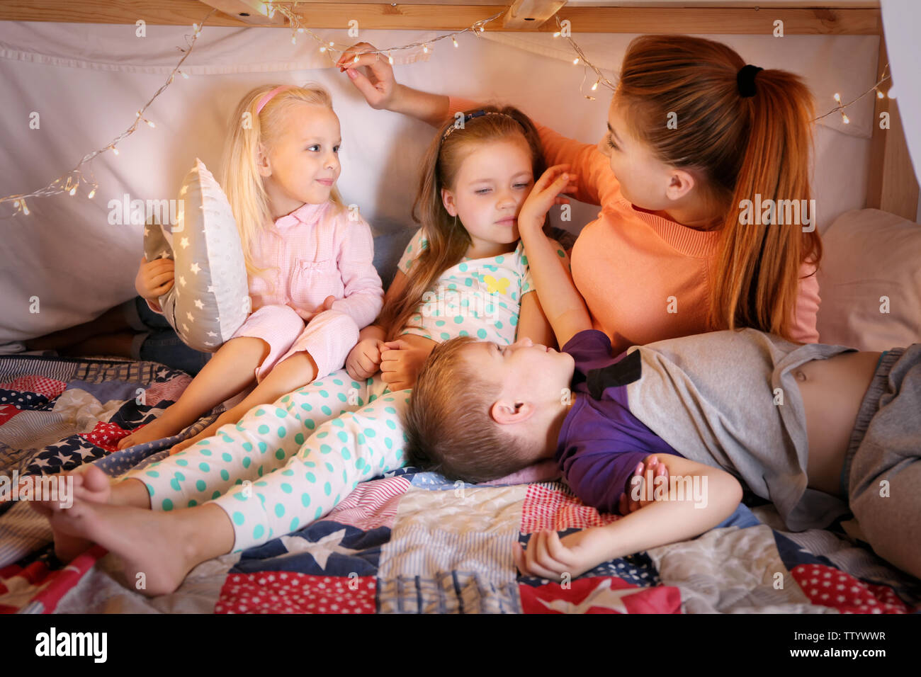 Young woman and cute children playing in hovel at home Stock Photo - Alamy