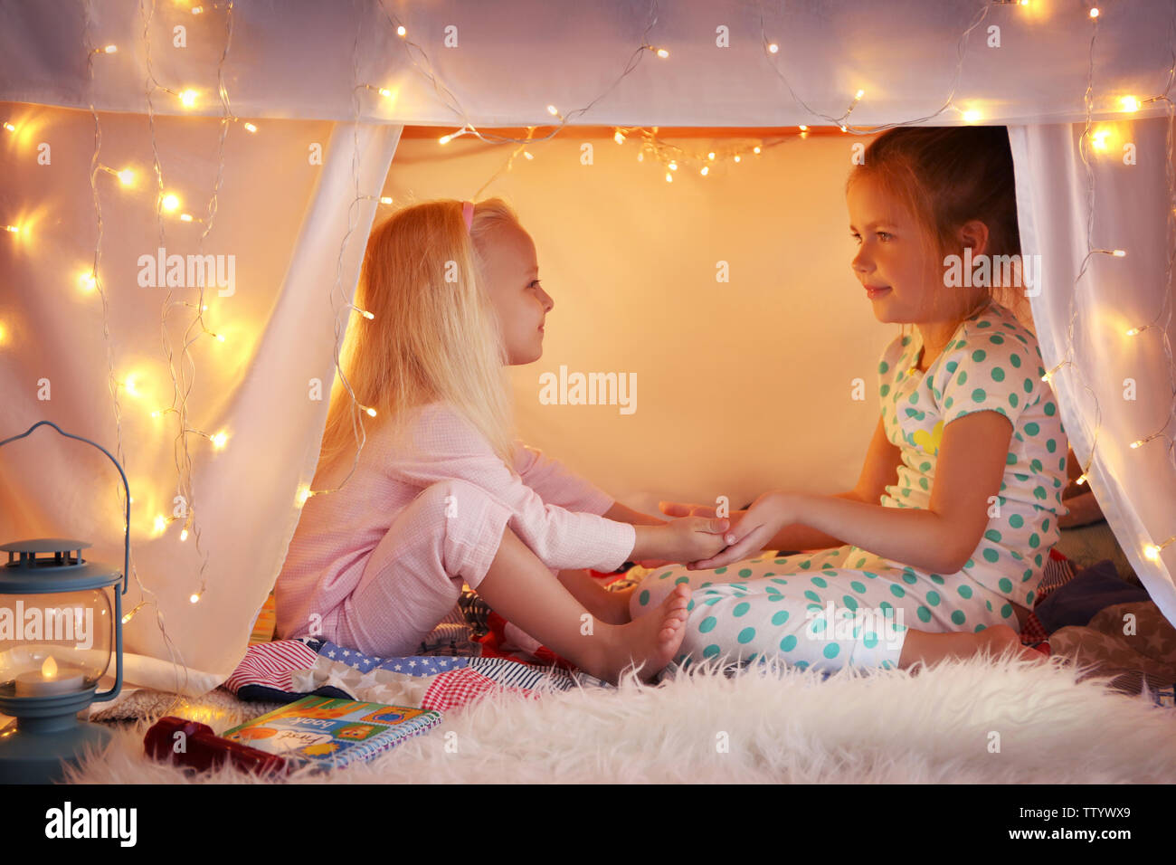 Cute little girls playing in hovel at home Stock Photo - Alamy