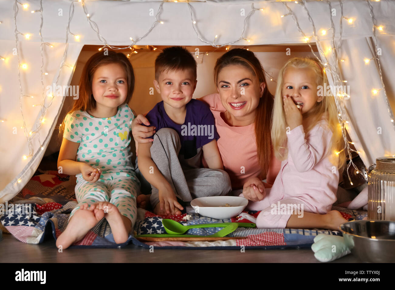 Young woman and cute children playing in hovel at home Stock Photo - Alamy
