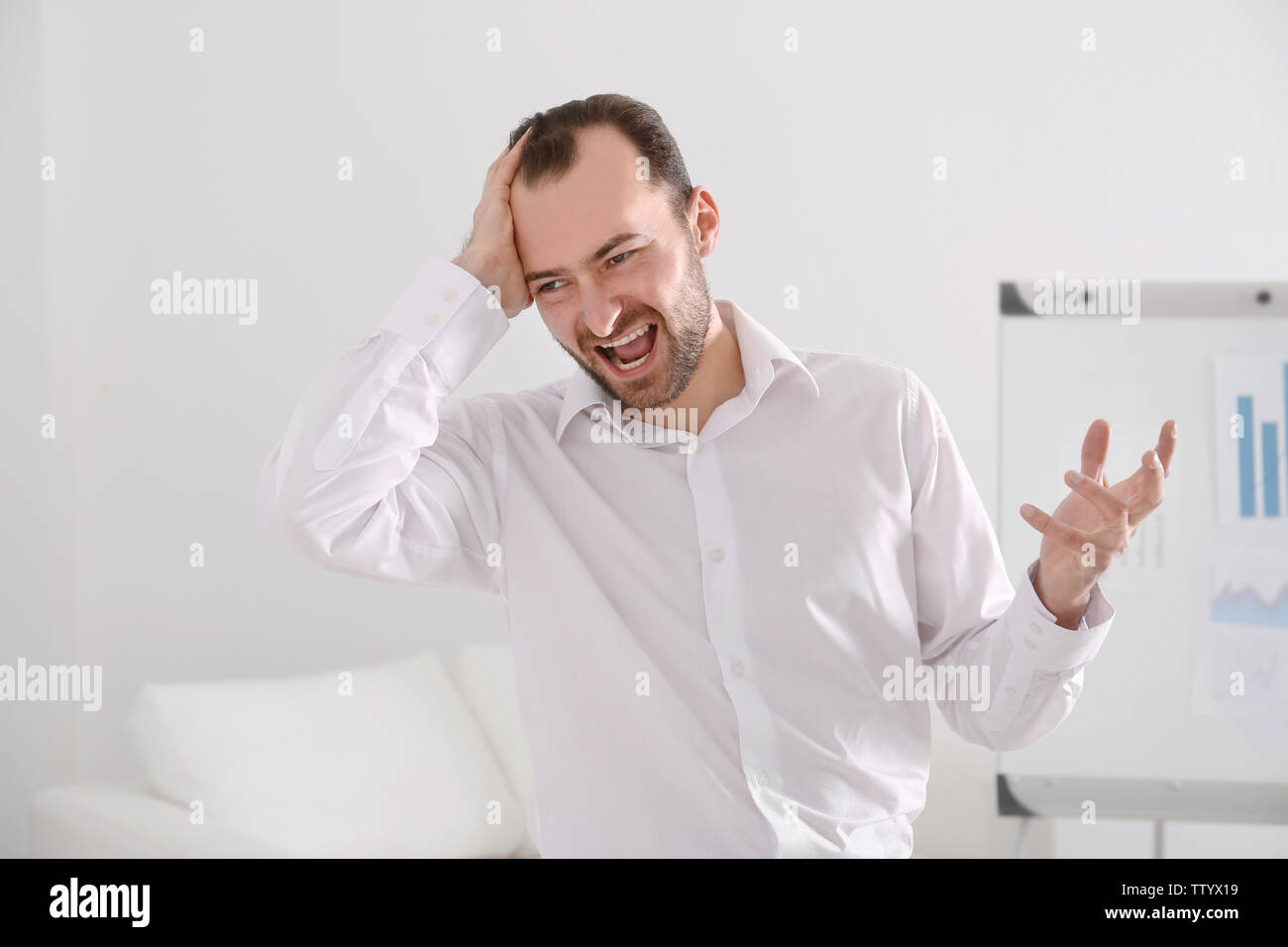 Handsome angry man in office Stock Photo - Alamy