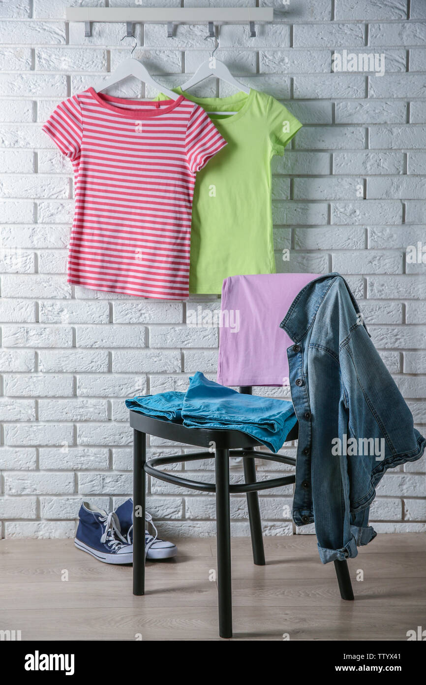 Pile of clothes on wooden chair Stock Photo - Alamy