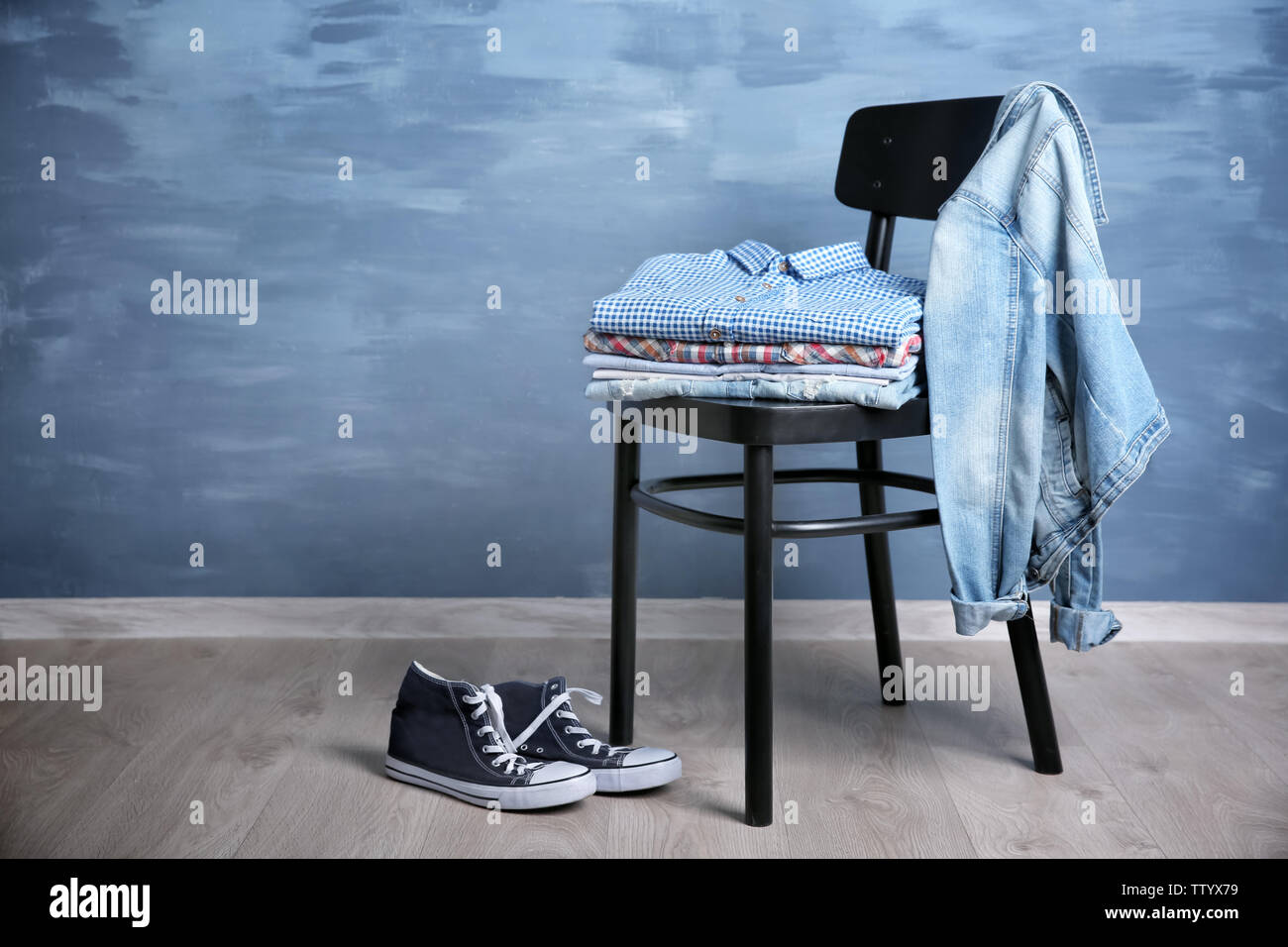 Pile of clothes on wooden chair Stock Photo - Alamy