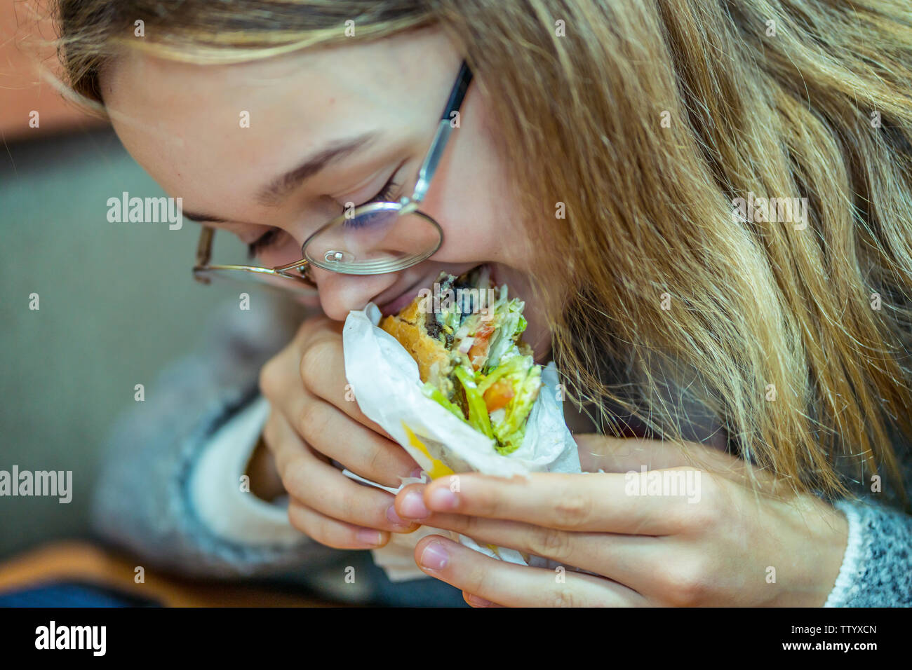 Girl eats fast food at the cafe Junk food, concept Stock Photo - Alamy