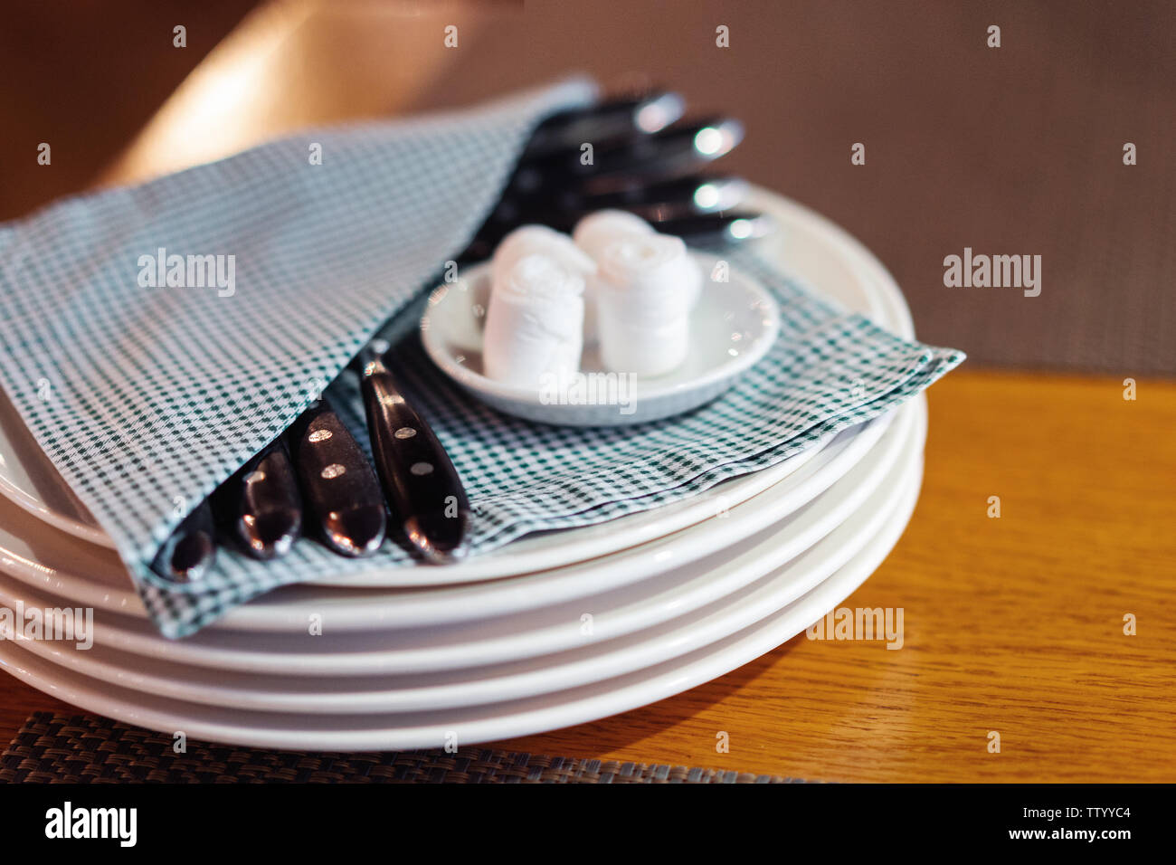 Table setting in restaurante. Stack of plates with set of forks, nifes ...
