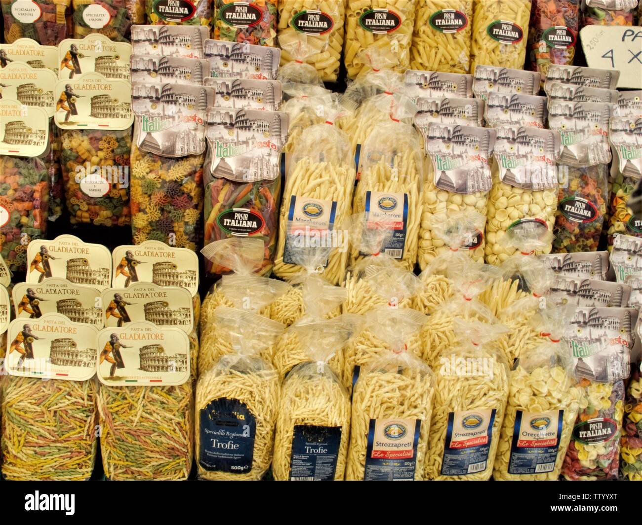 Packets of colorful italian pasta at a counter in an outdoor market ...