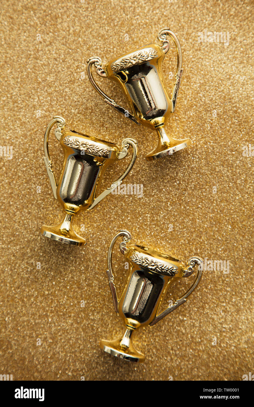 Gold winners achievement trophy on a gold glitter background Stock ...