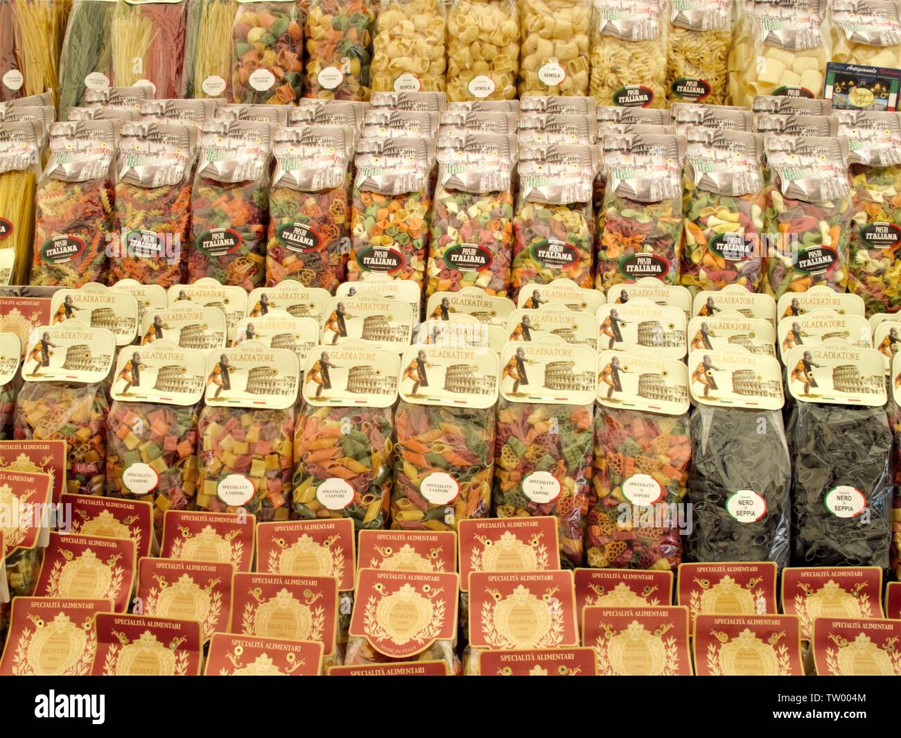 Packets of colorful italian pasta at a counter in an outdoor market ...