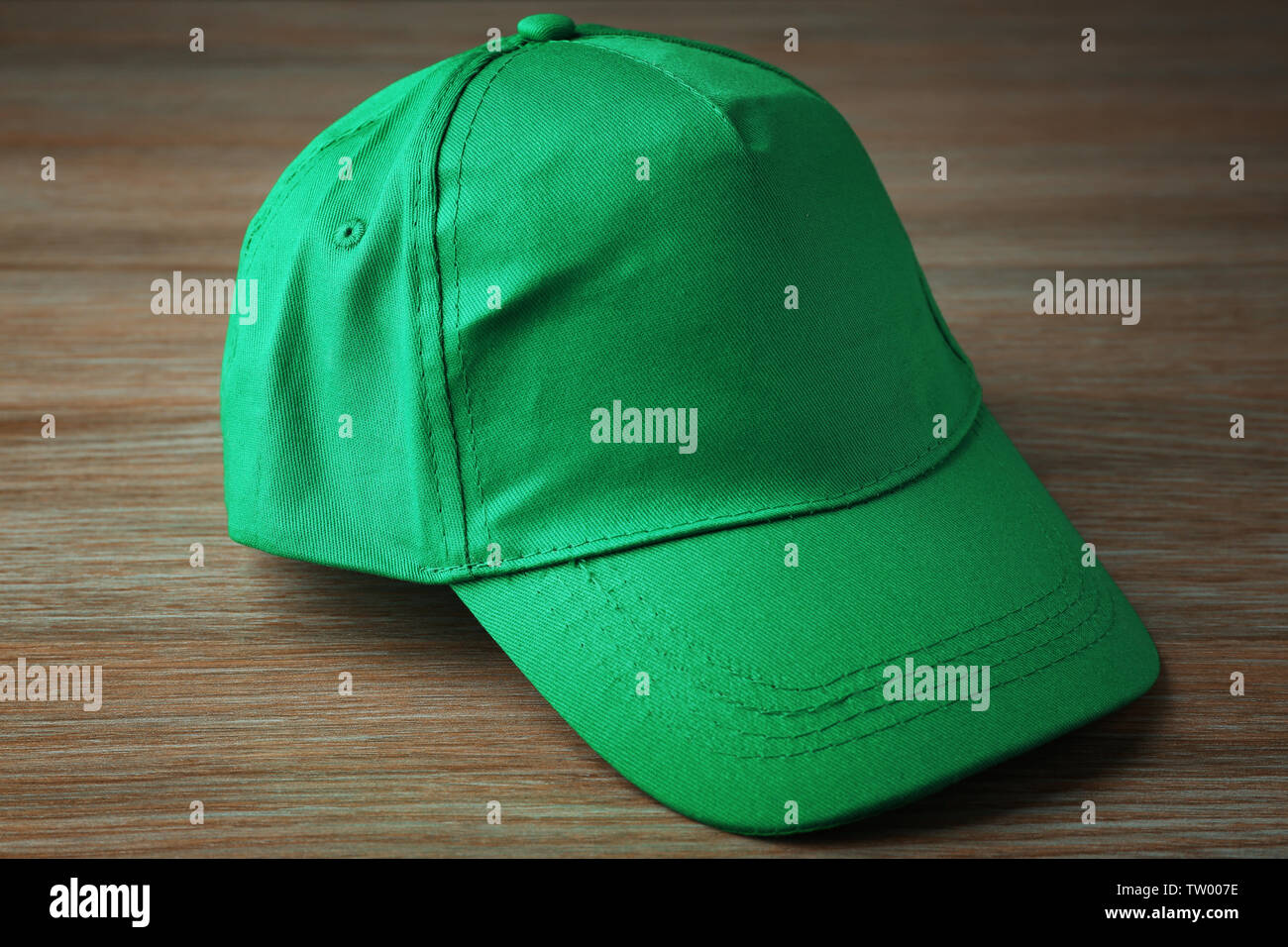 Blank green baseball cap on wooden background Stock Photo - Alamy