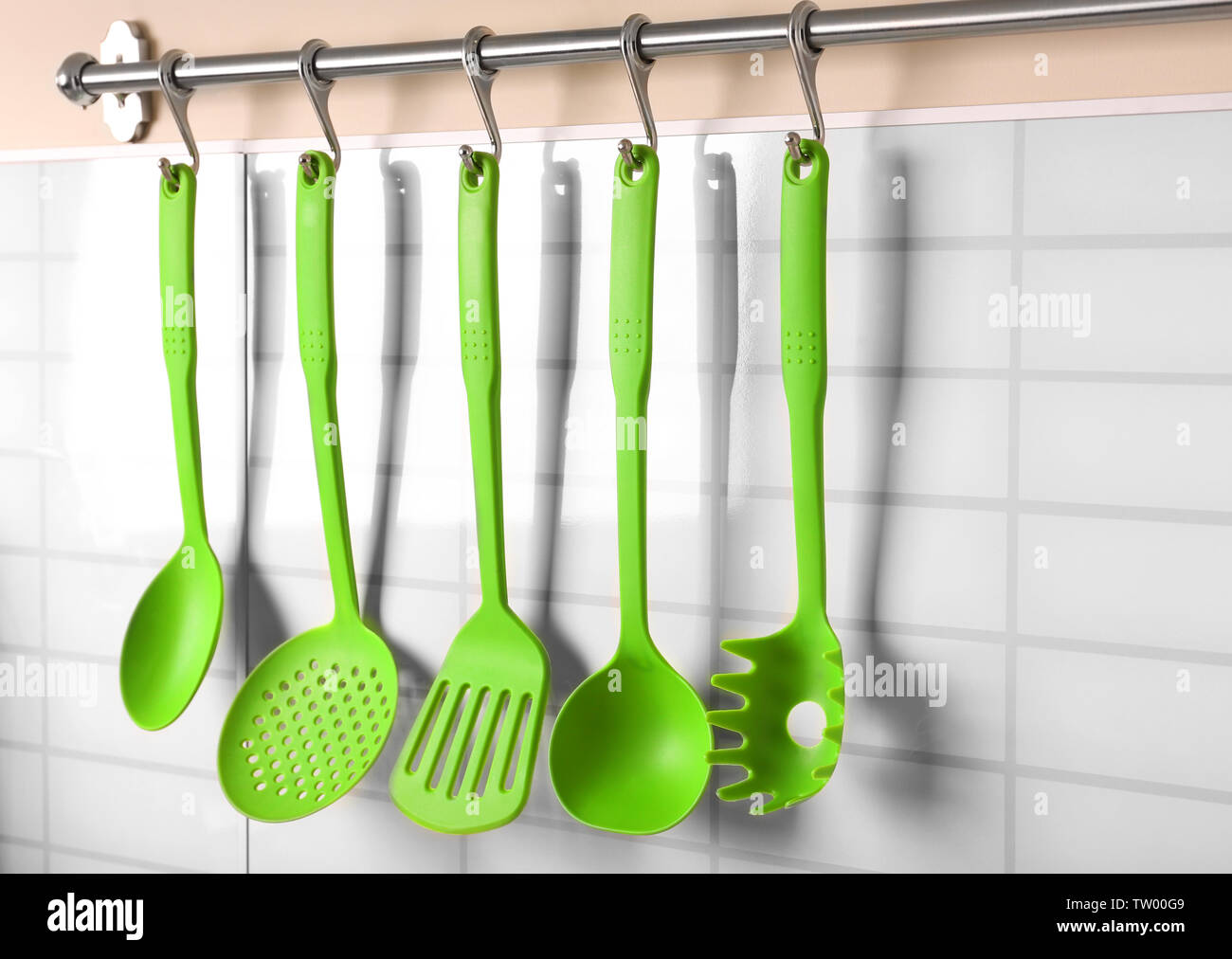 Set of kitchen utensils hanging on the wall Stock Photo - Alamy