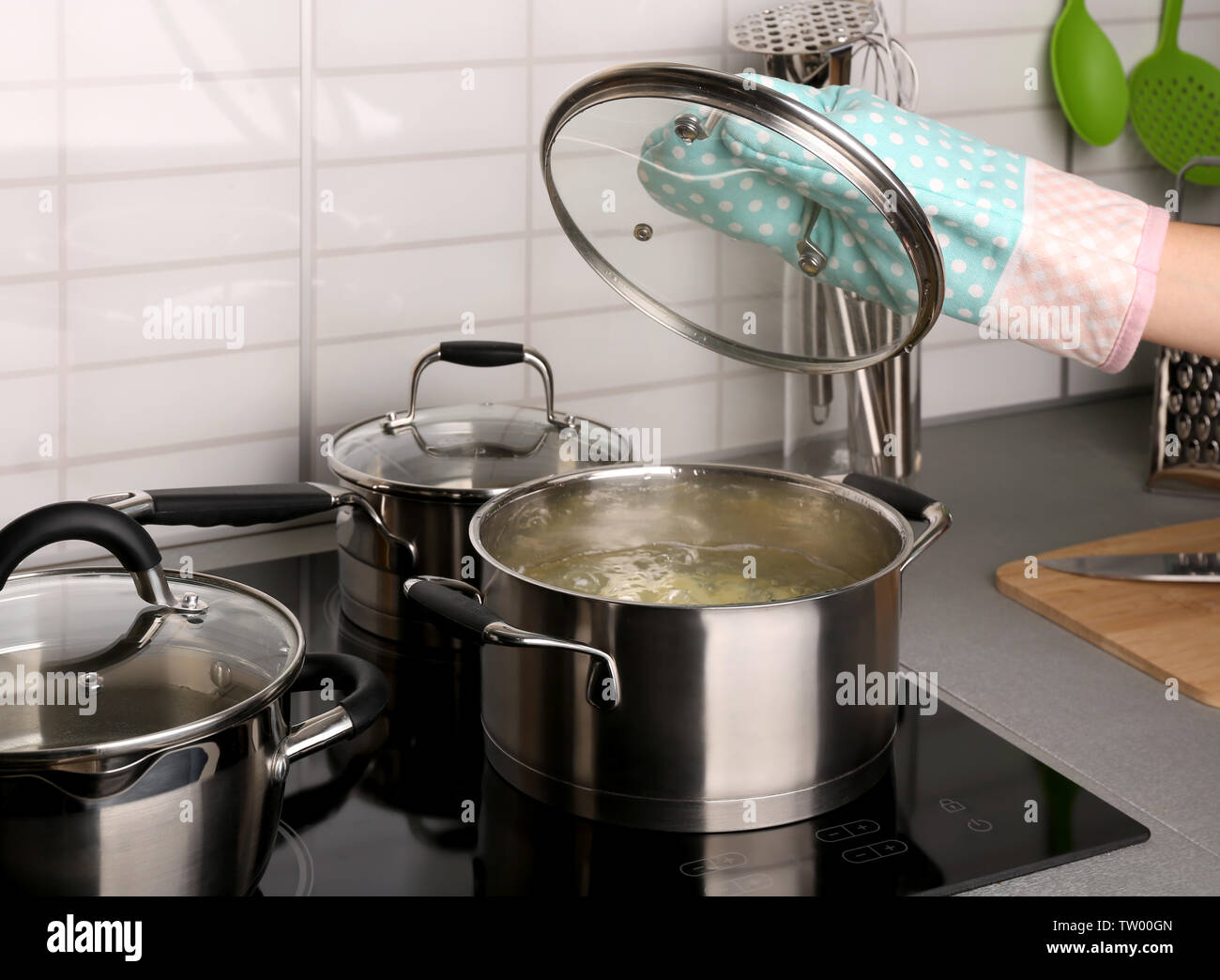 Female hand holding lid from saucepan Stock Photo - Alamy