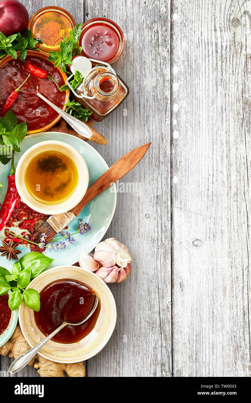 Border of assorted marinades and sauces, spices and herbs on rustic ...